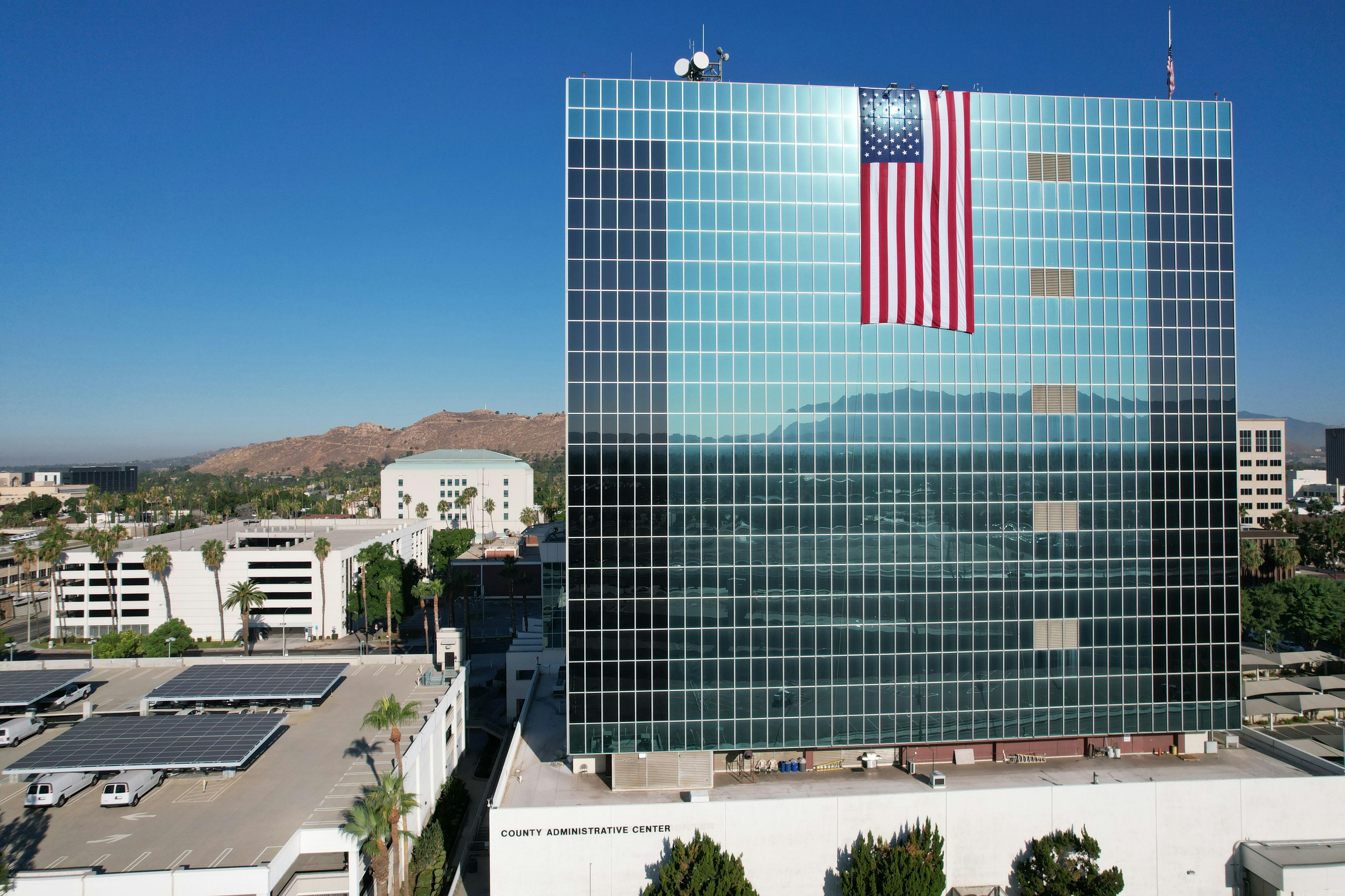 American Flag Hanging on a Glass Building · Free Stock Photo
