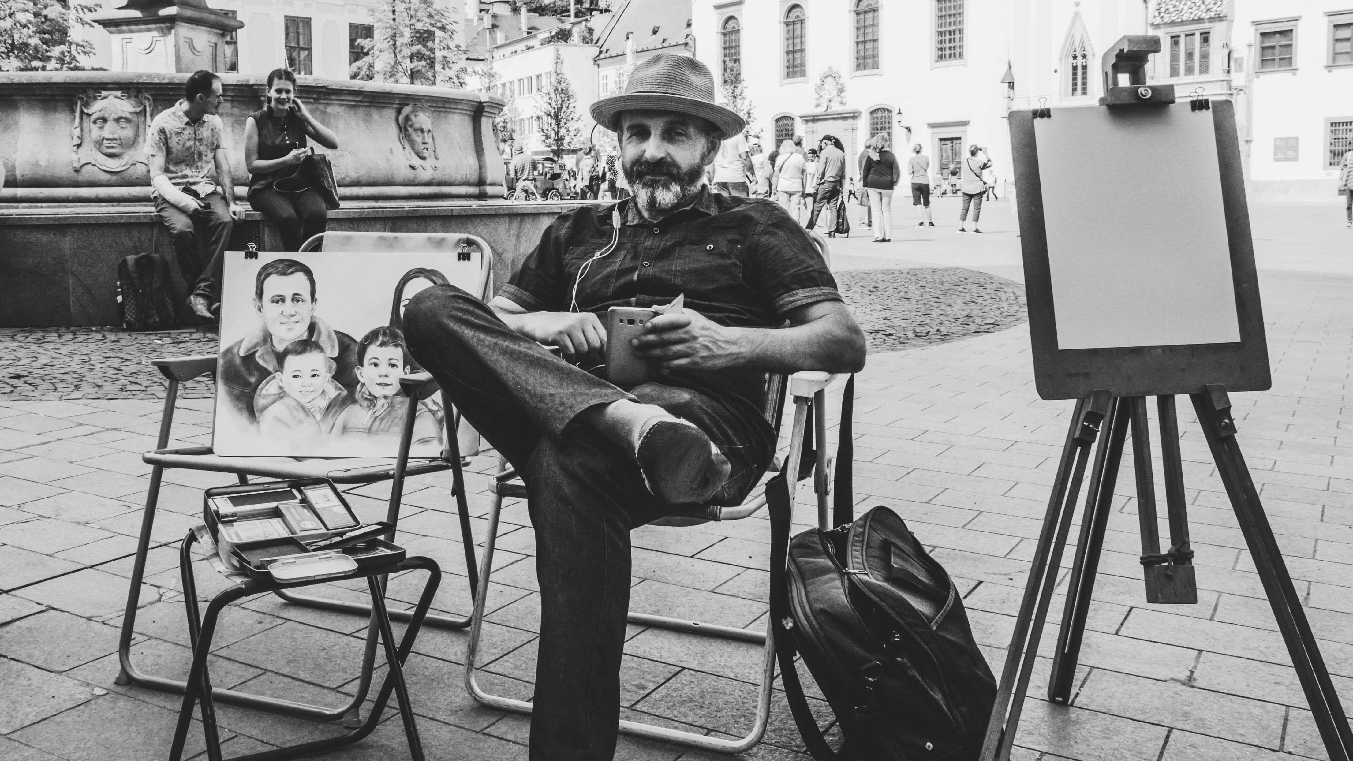 Grayscale Photo of Man Wearing Black Dress Shirt With Hat Sitting on ...