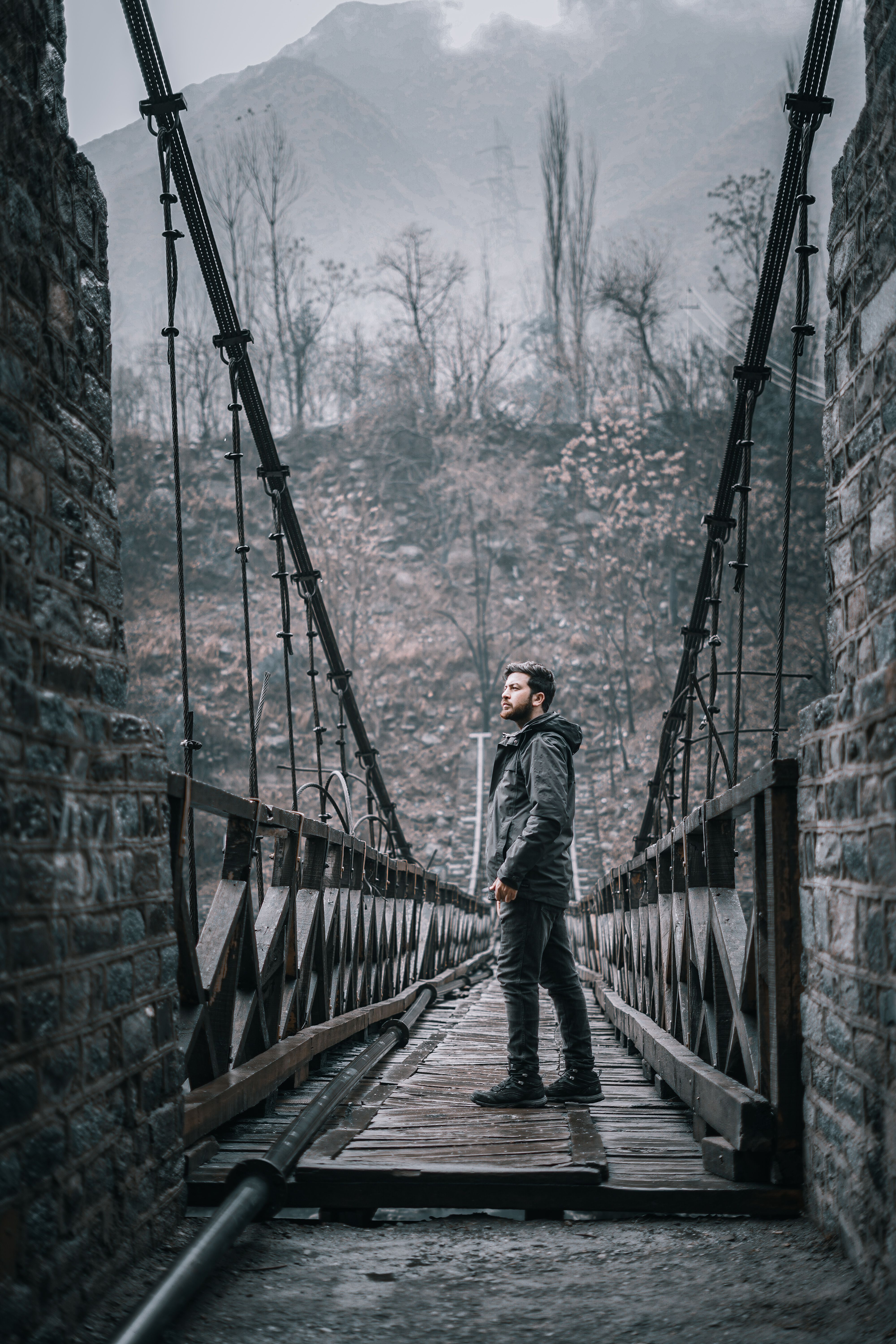 A Man in Black Jacket Walking on Hanging Bridge · Free Stock Photo