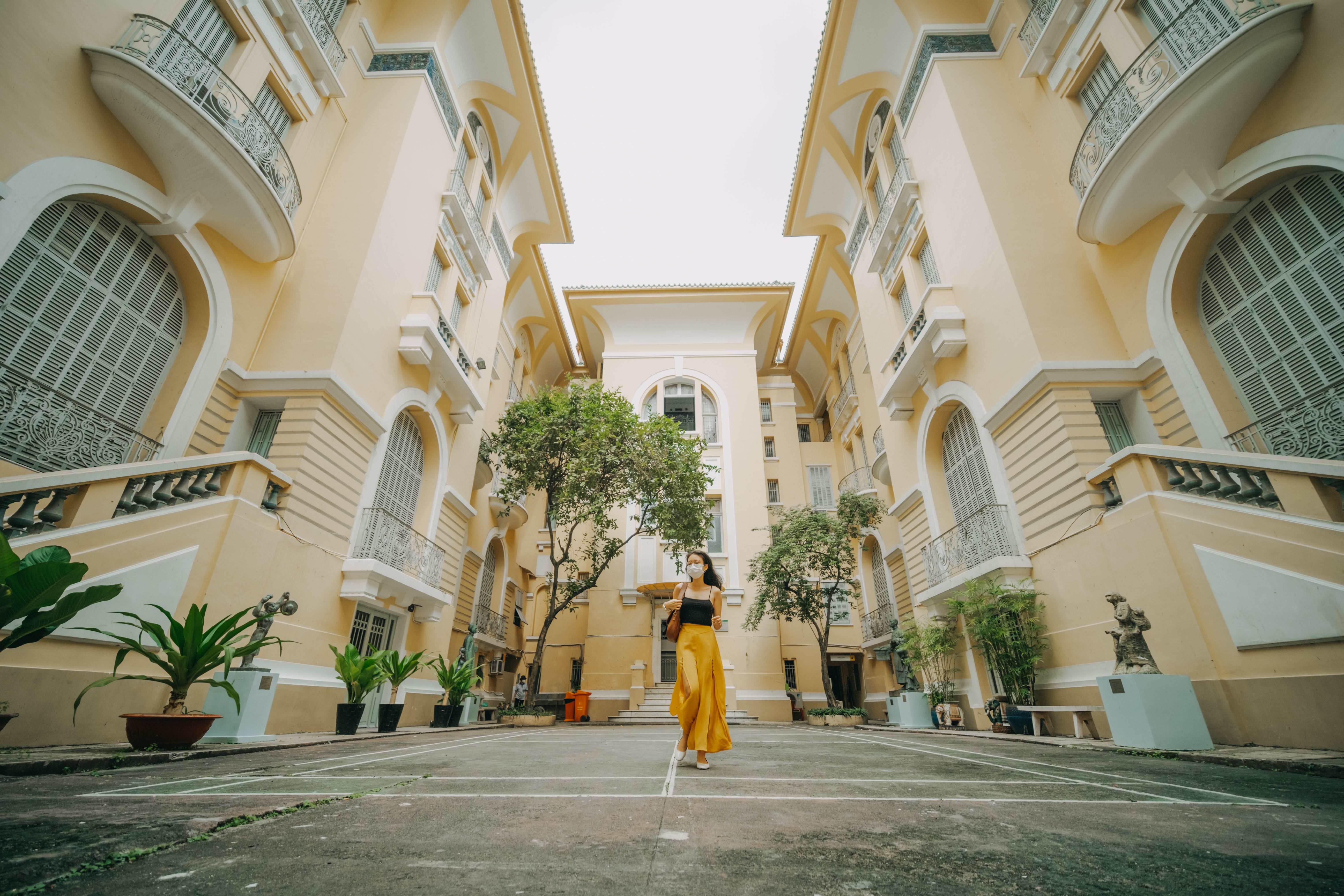 A Woman in a Face Mask Walking Outside a Building · Free Stock Photo