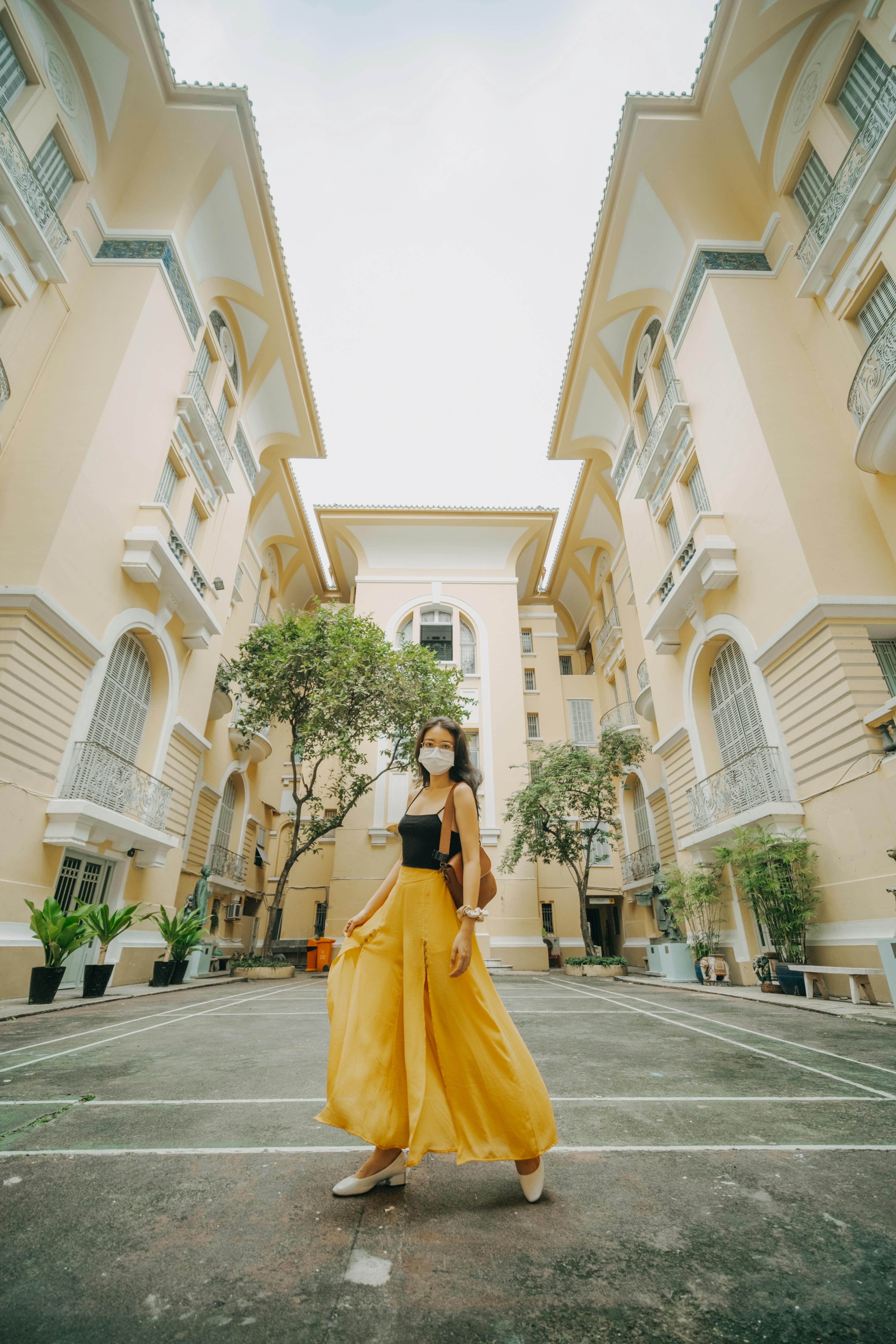 Photo of a Woman Posing Between Buildings · Free Stock Photo