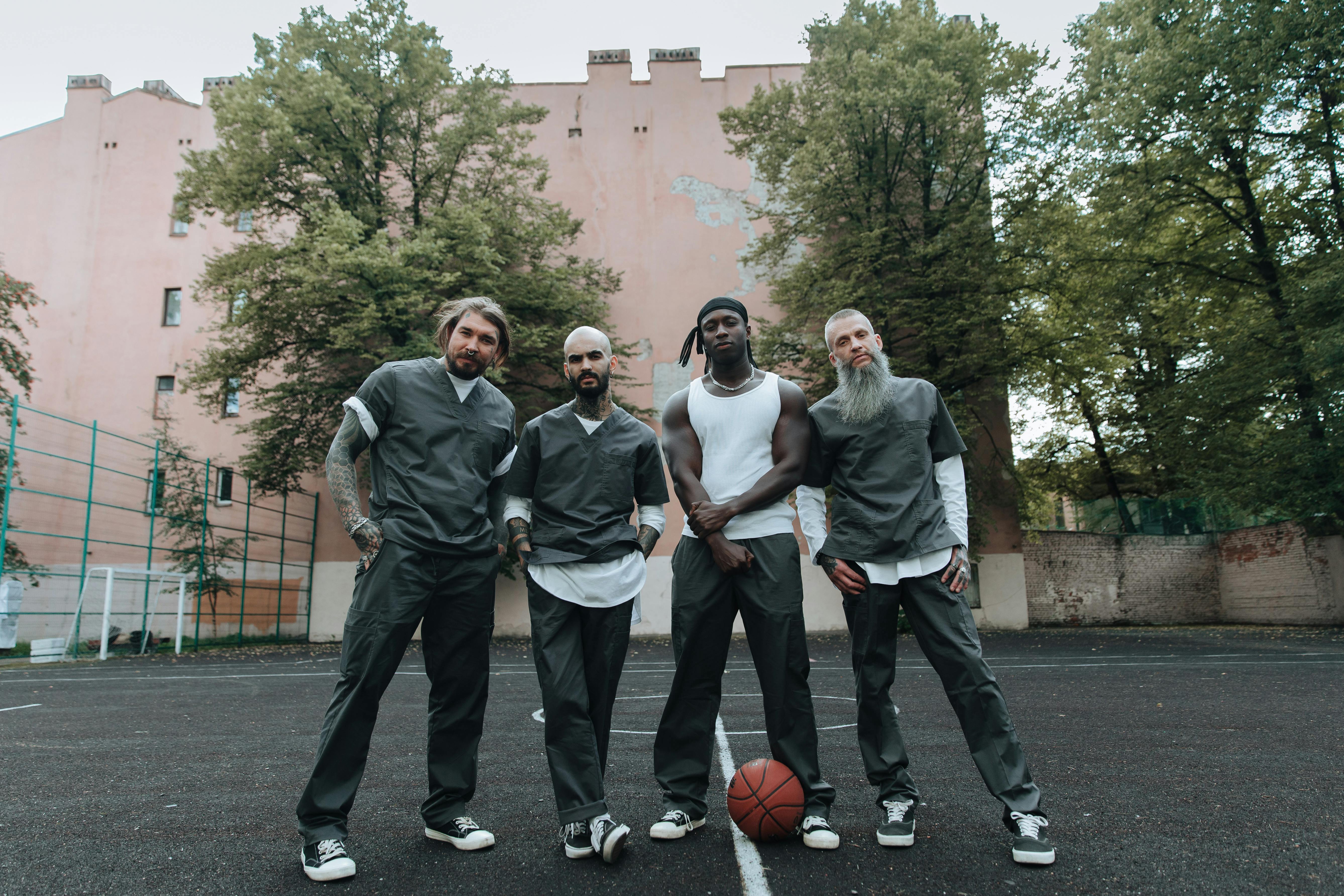 Four Man Standing on Yard · Free Stock Photo