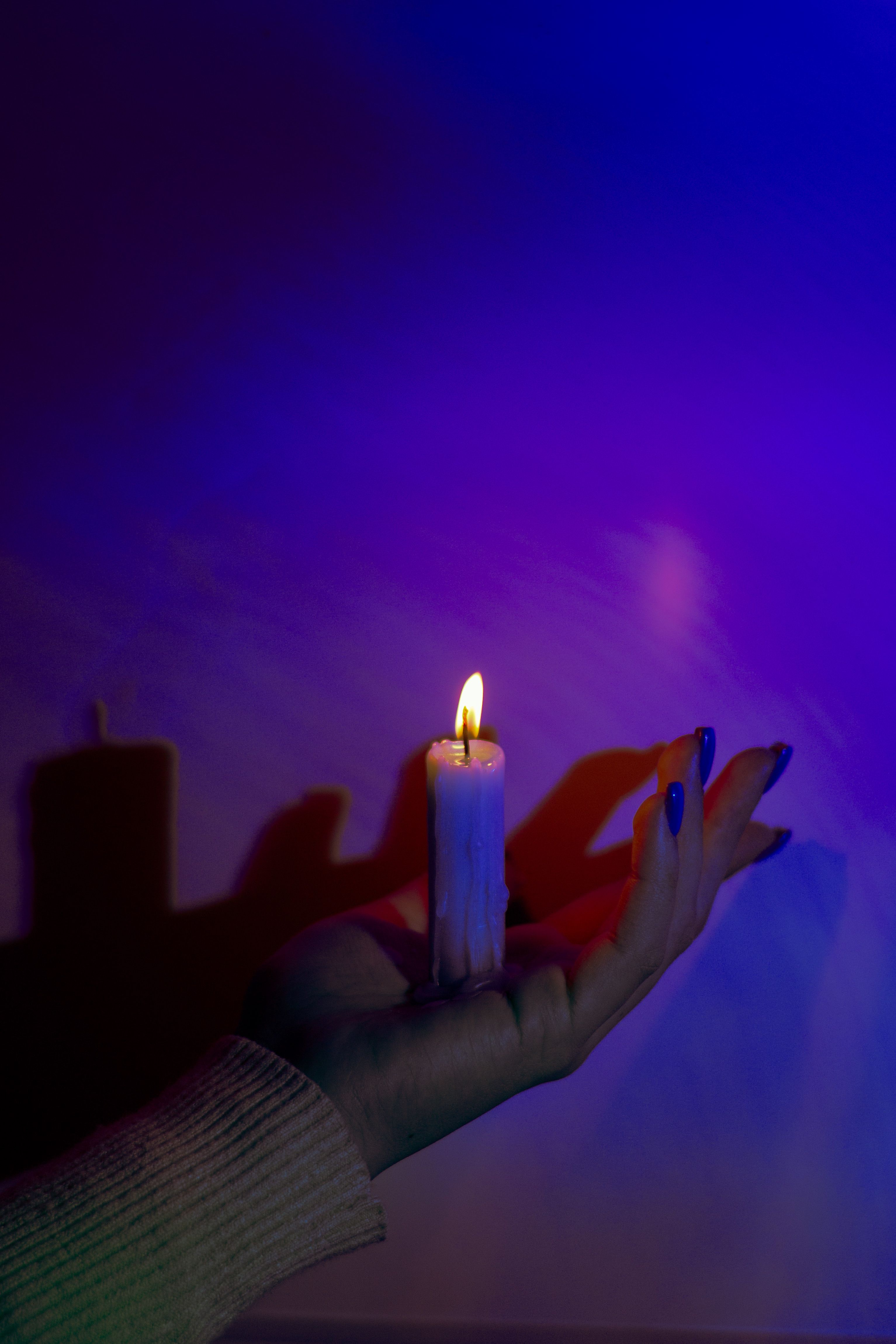 Woman Lighting a Candle on a Table · Free Stock Photo