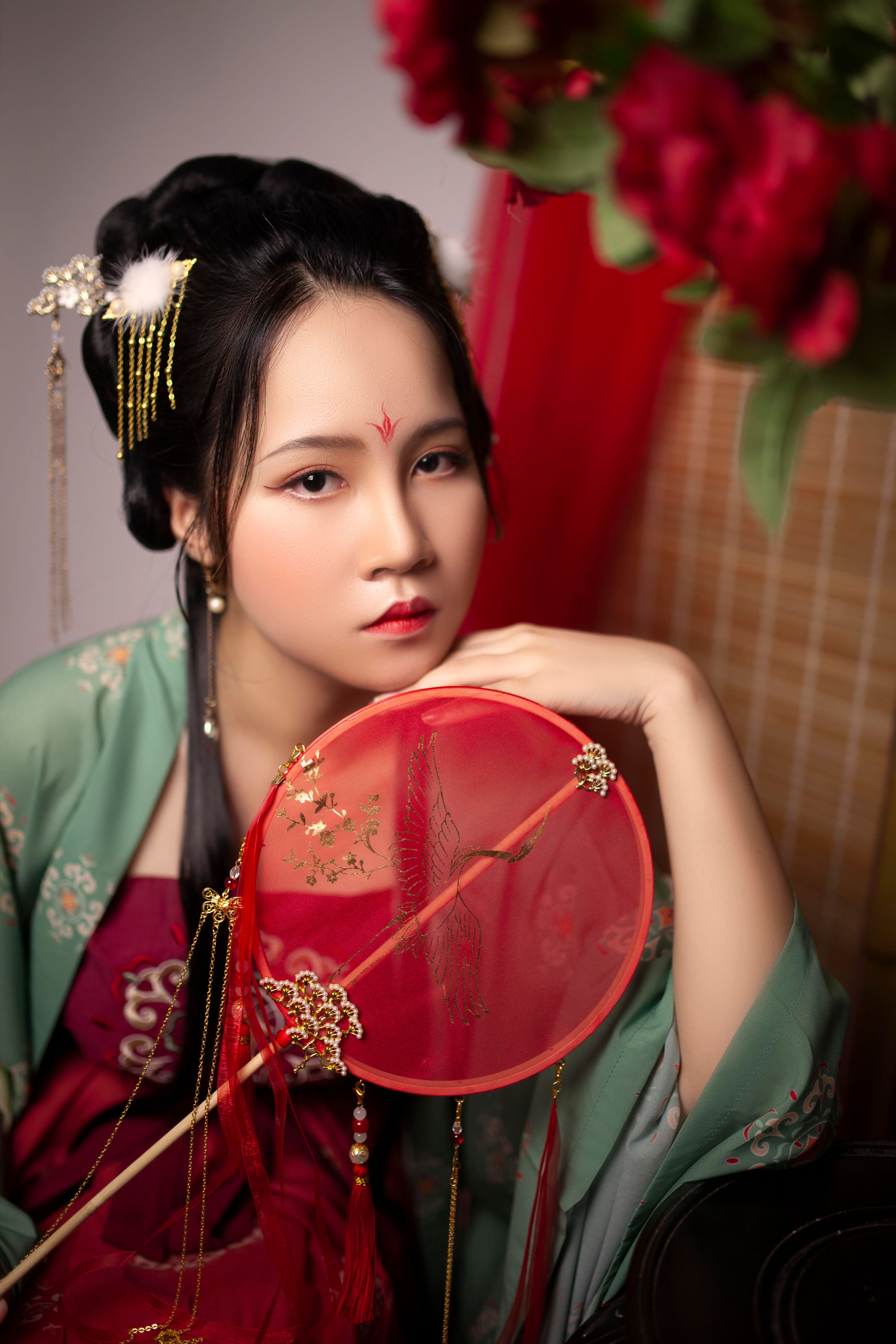 A Woman Holding a Red Hand Fan · Free Stock Photo