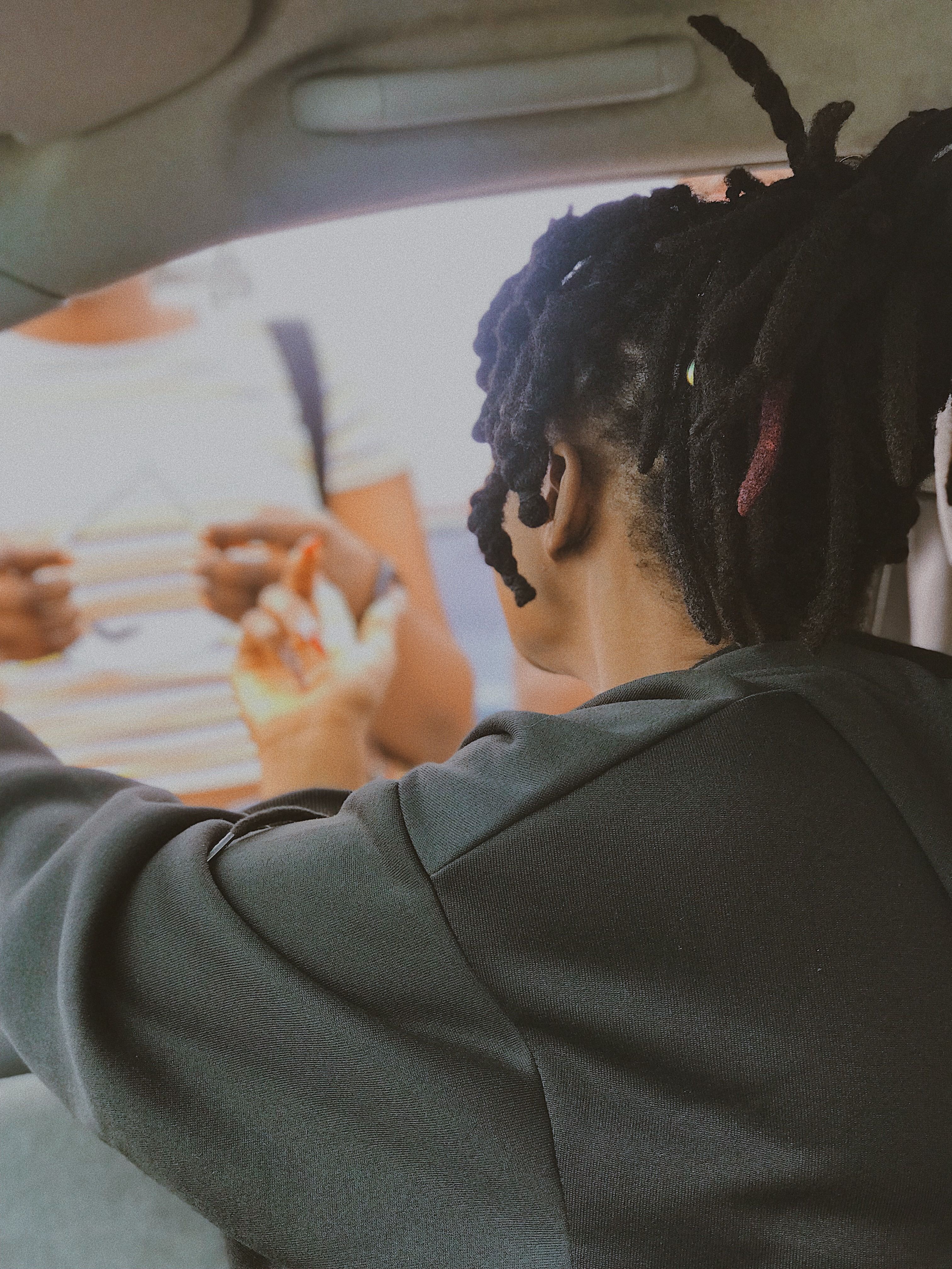 Back View of a Person with Dreadlocks inside a Car · Free Stock Photo