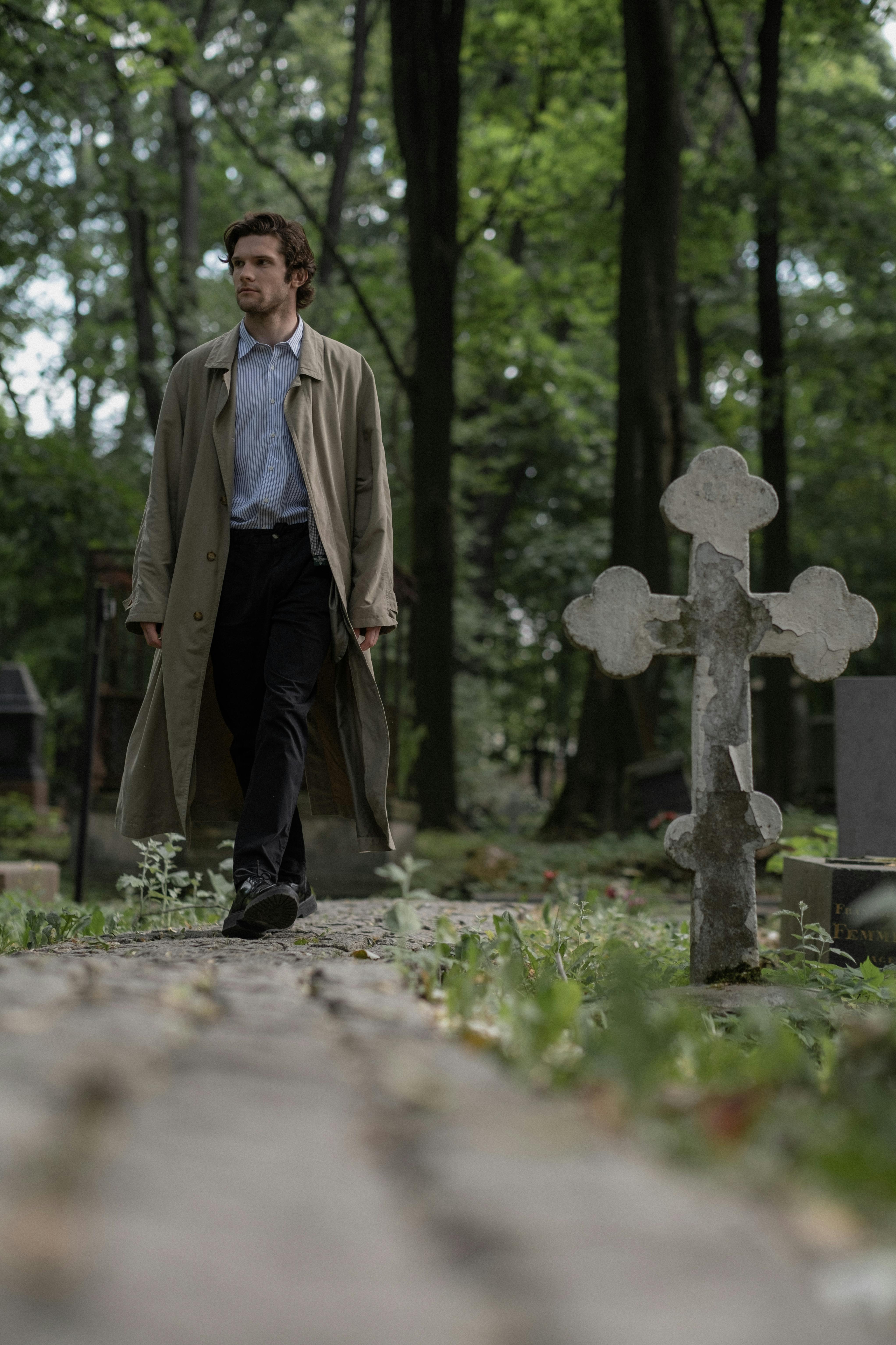 A Man Walking in a Cemetery · Free Stock Photo