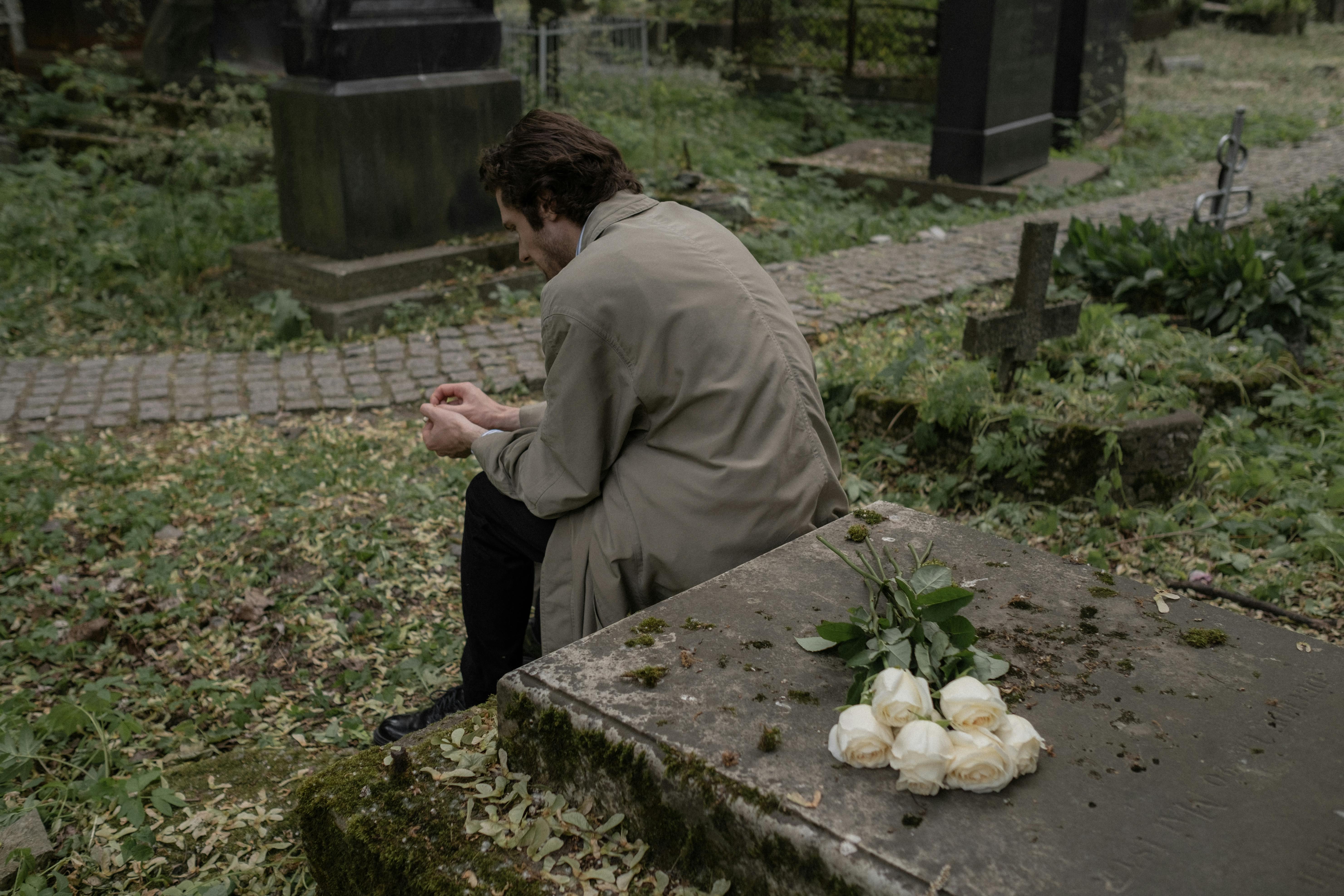 A Man Sitting by a Grave · Free Stock Photo