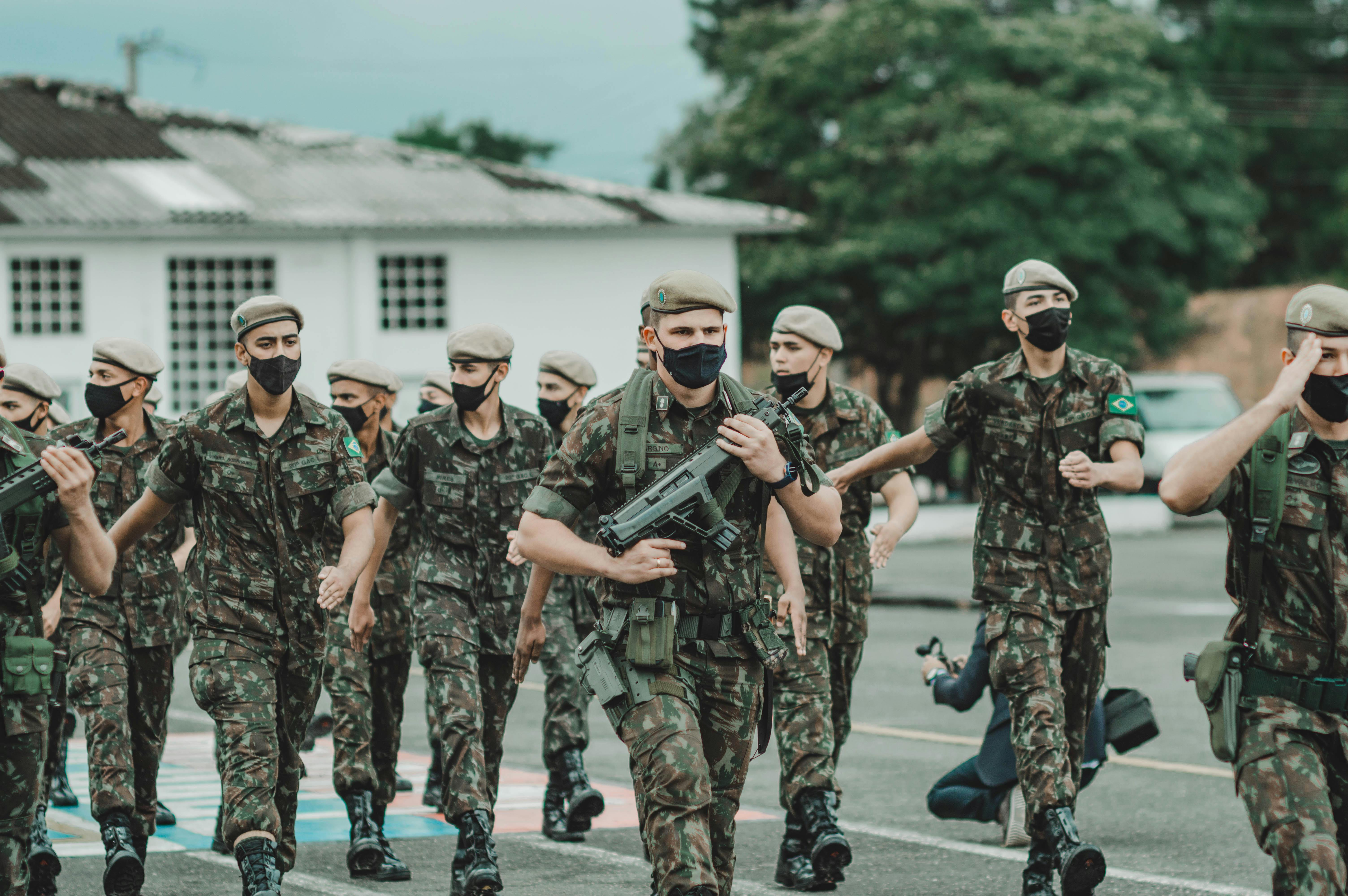 Soldier Sliding Downhill Holding Rifle during Daytime · Free Stock Photo