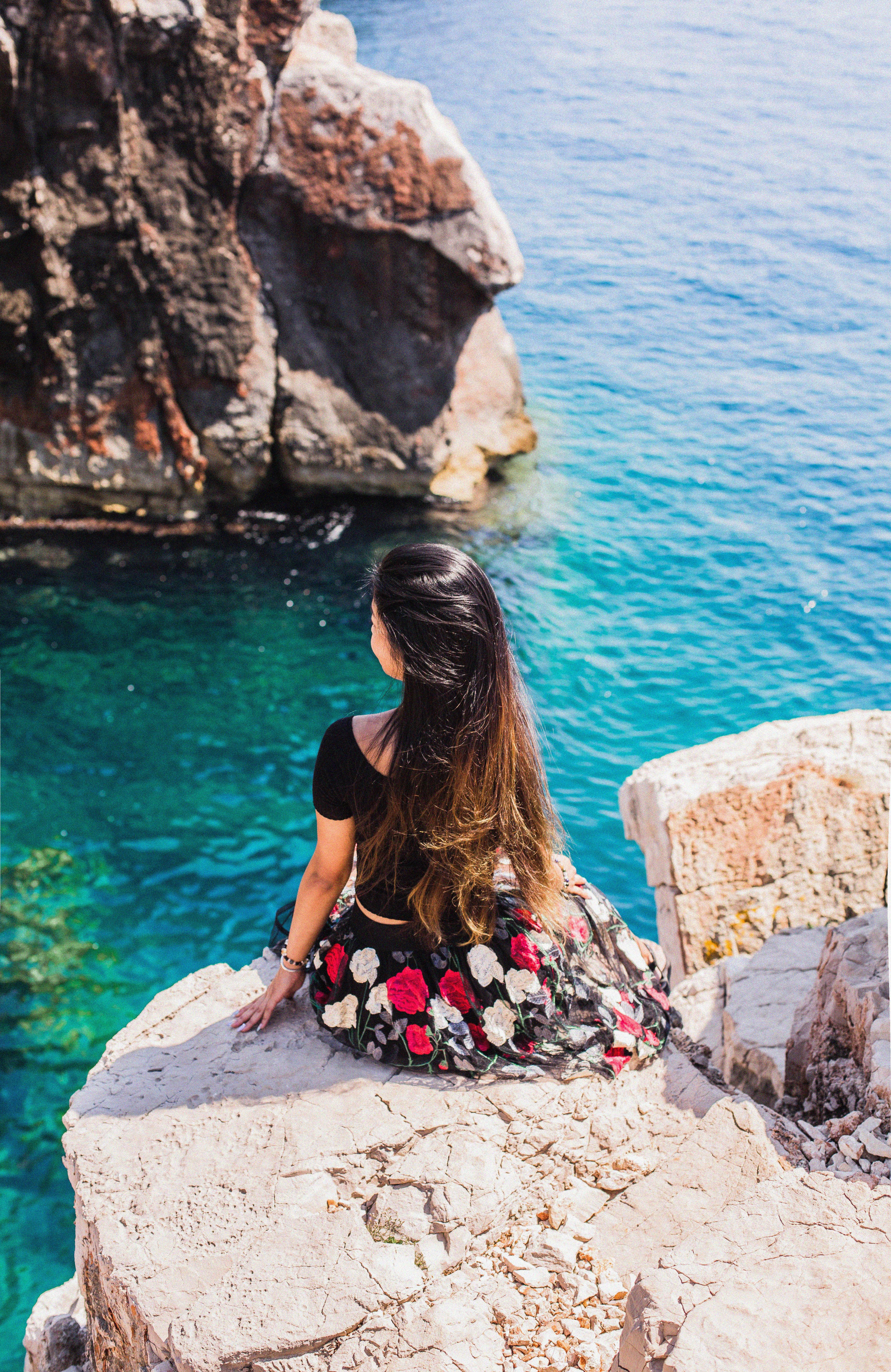 Photo of a Woman Sitting on the Cliff · Free Stock Photo