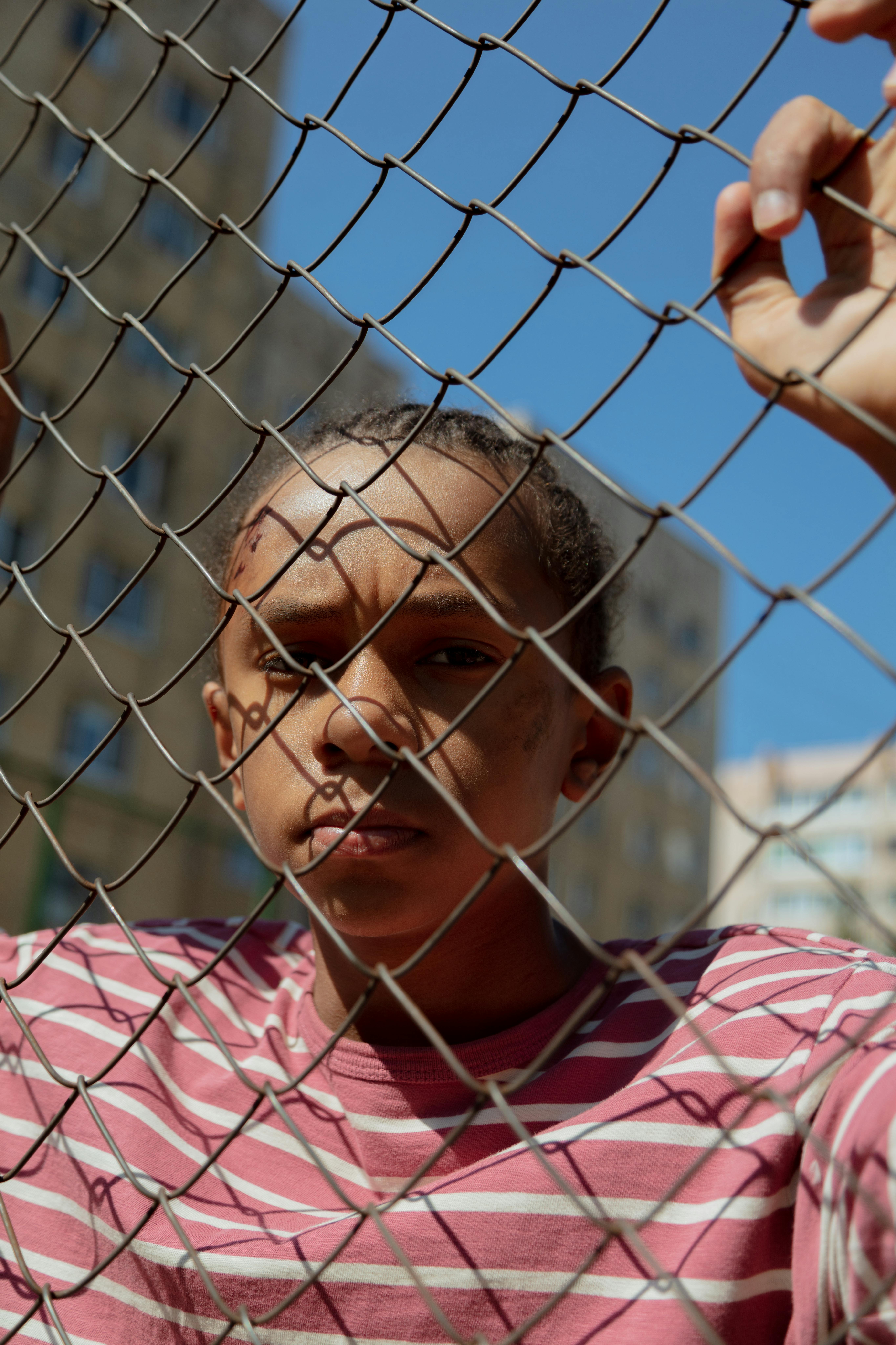 A Boy Behind a Wire Fence · Free Stock Photo