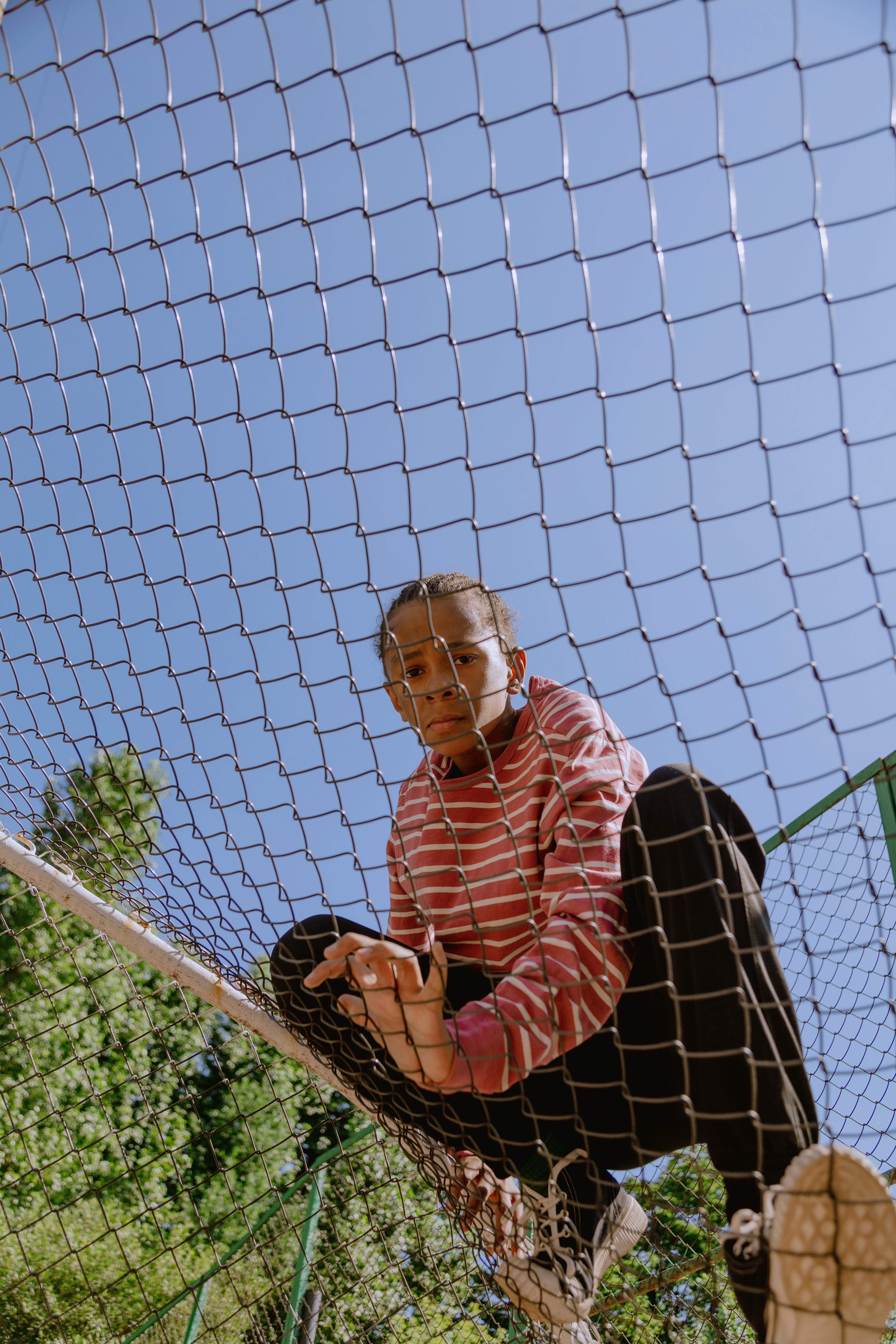 Boys Hiding Behind Mesh Fence · Free Stock Photo