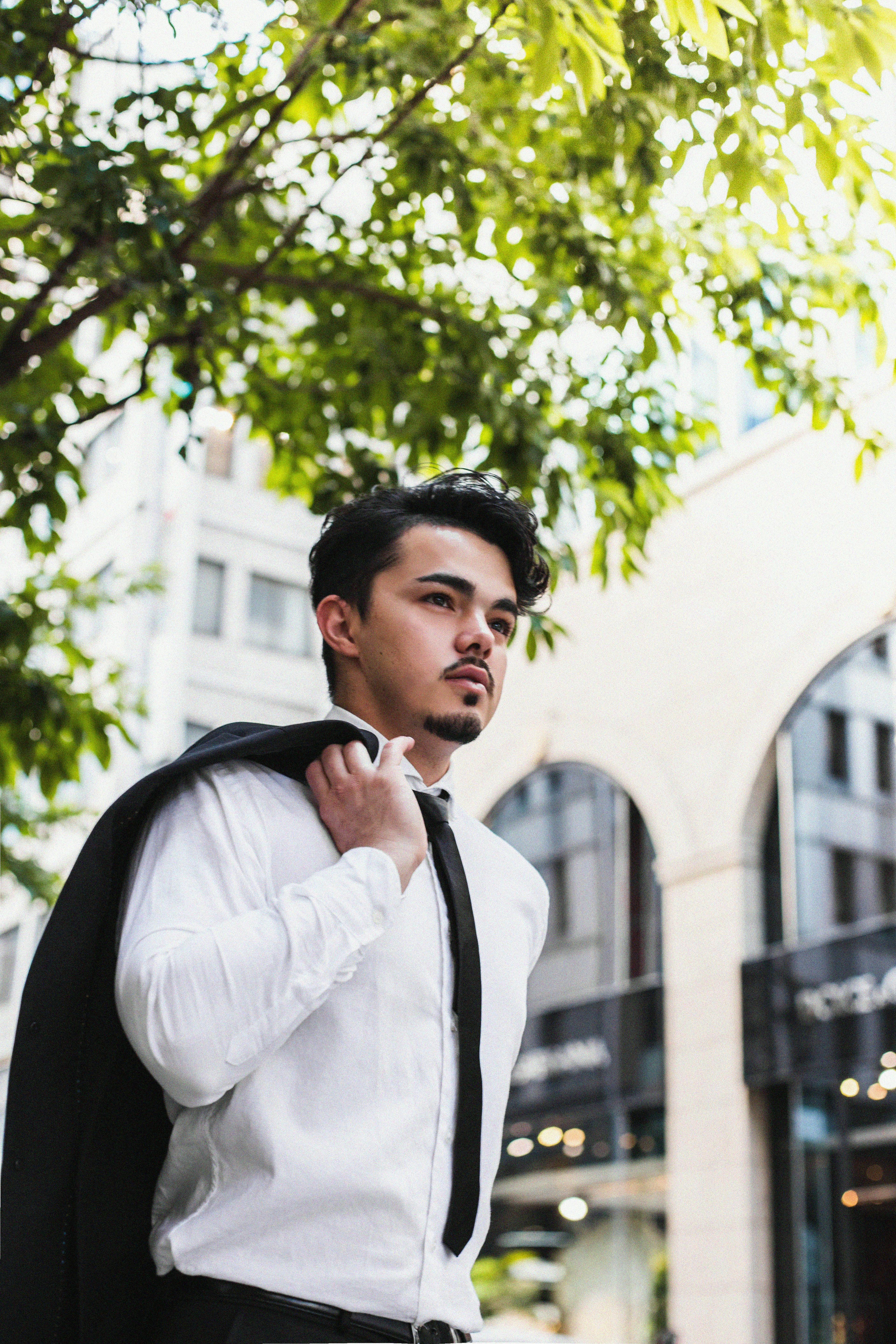 A Man Holding Suit Jacket over His Shoulder · Free Stock Photo