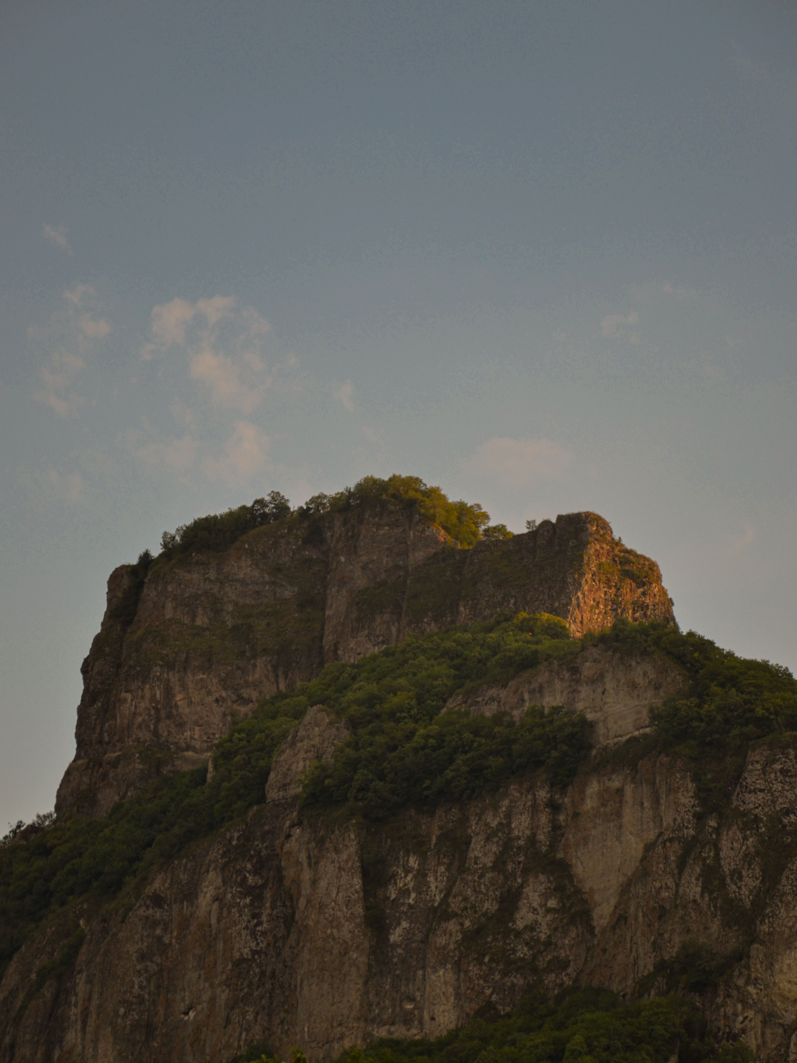 A Brown Cliff with Green Trees Under Blue Sky · Free Stock Photo