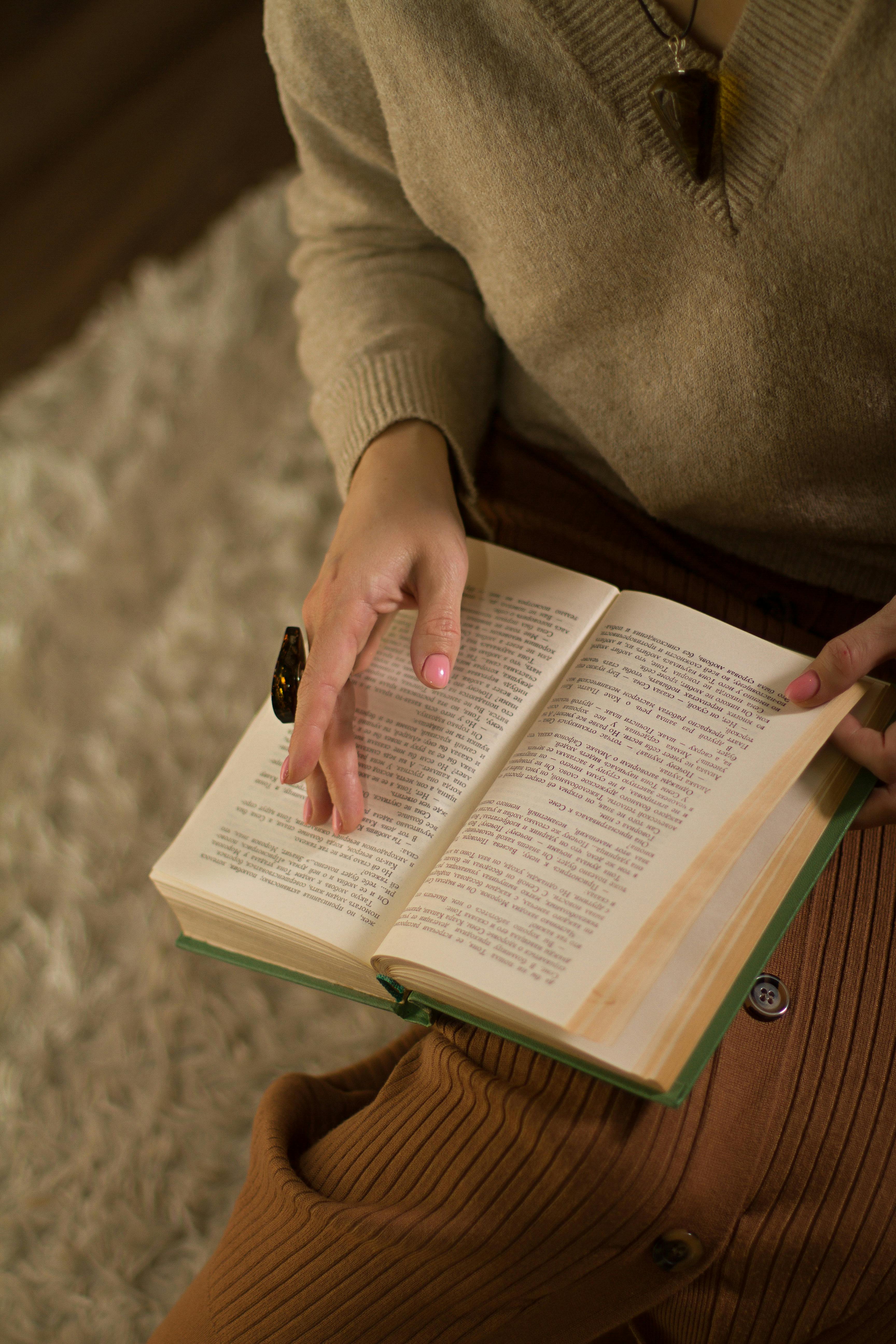 Close-up Photo of an Opened Book held by a Person · Free Stock Photo