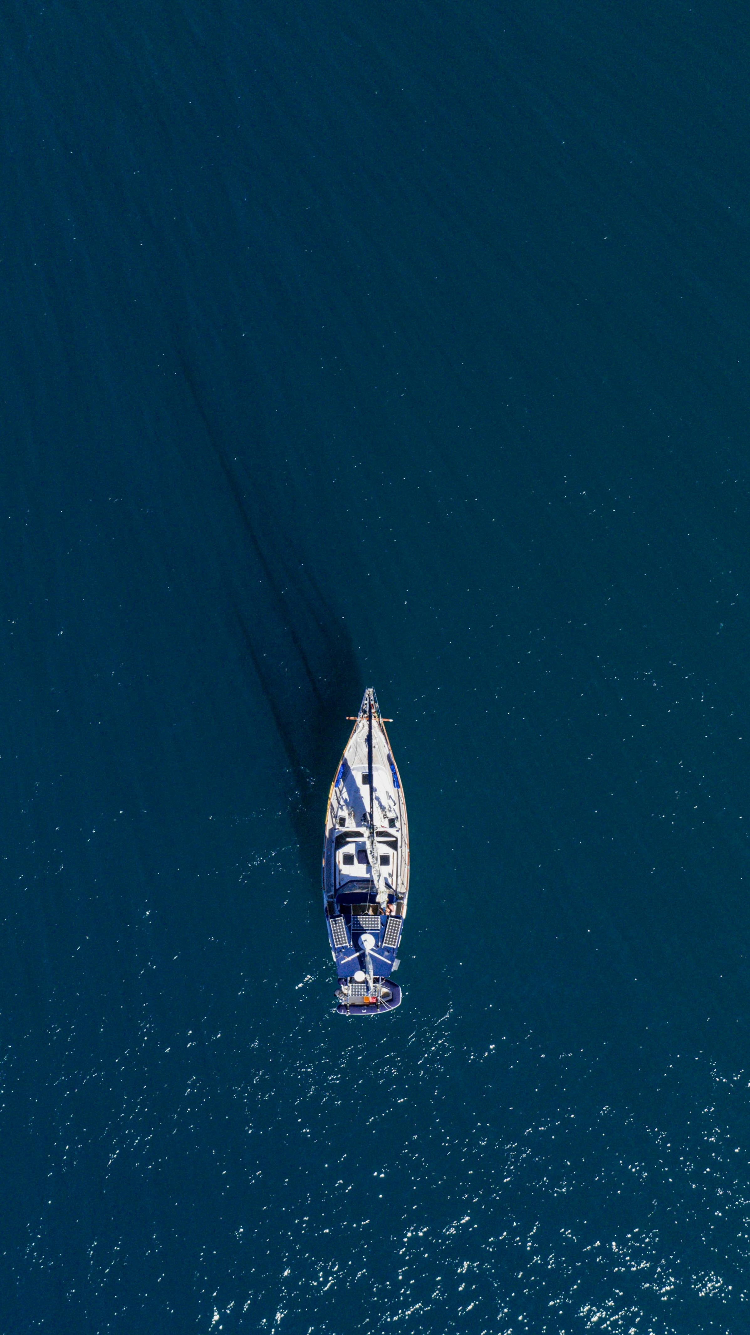 Aerial View of a White and Blue Boat on Blue Sea · Free Stock Photo