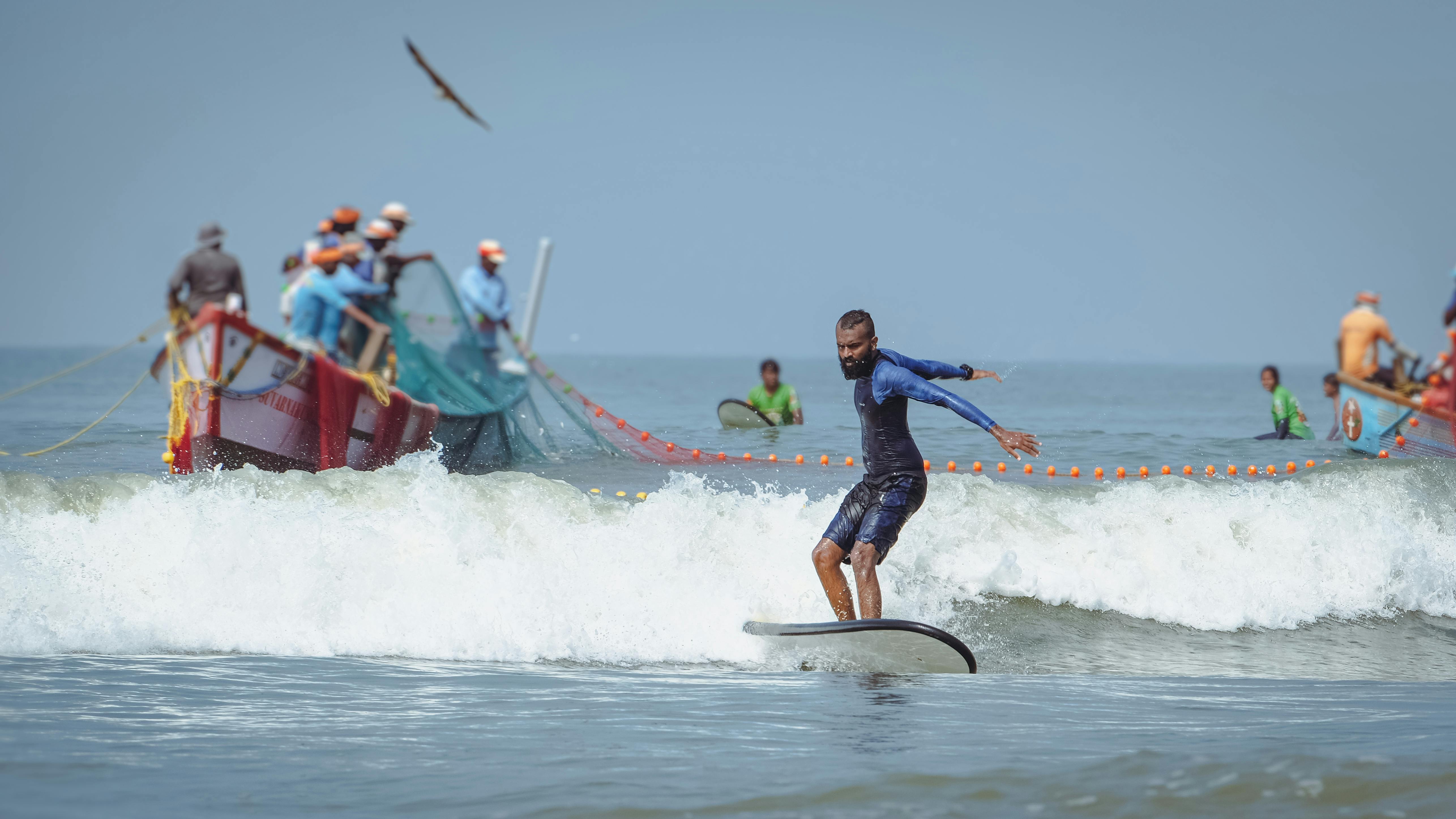 Photo of a Man Surfing Near a Boat · Free Stock Photo