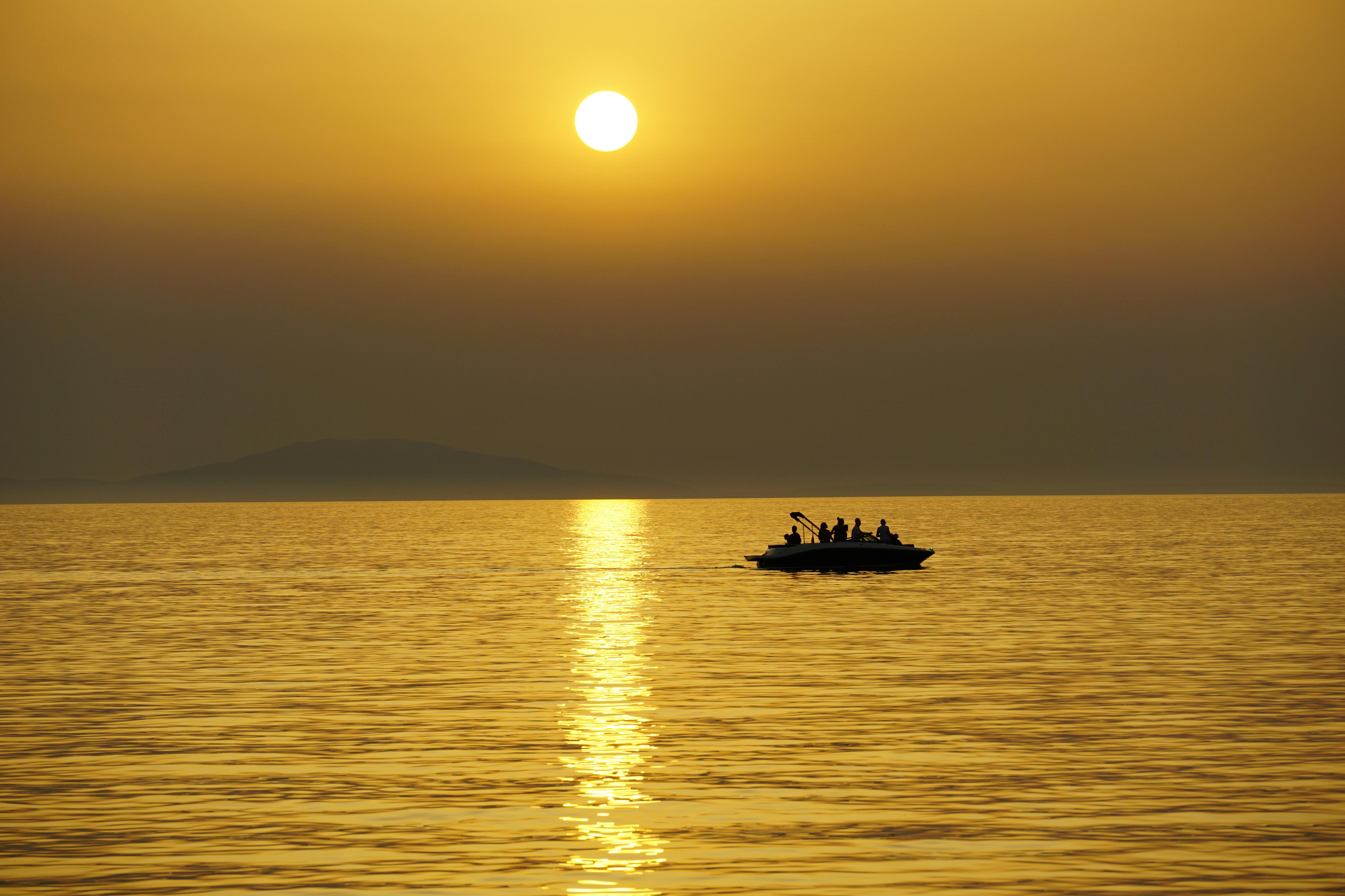 People on a Boat at Sea During Sunset · Free Stock Photo