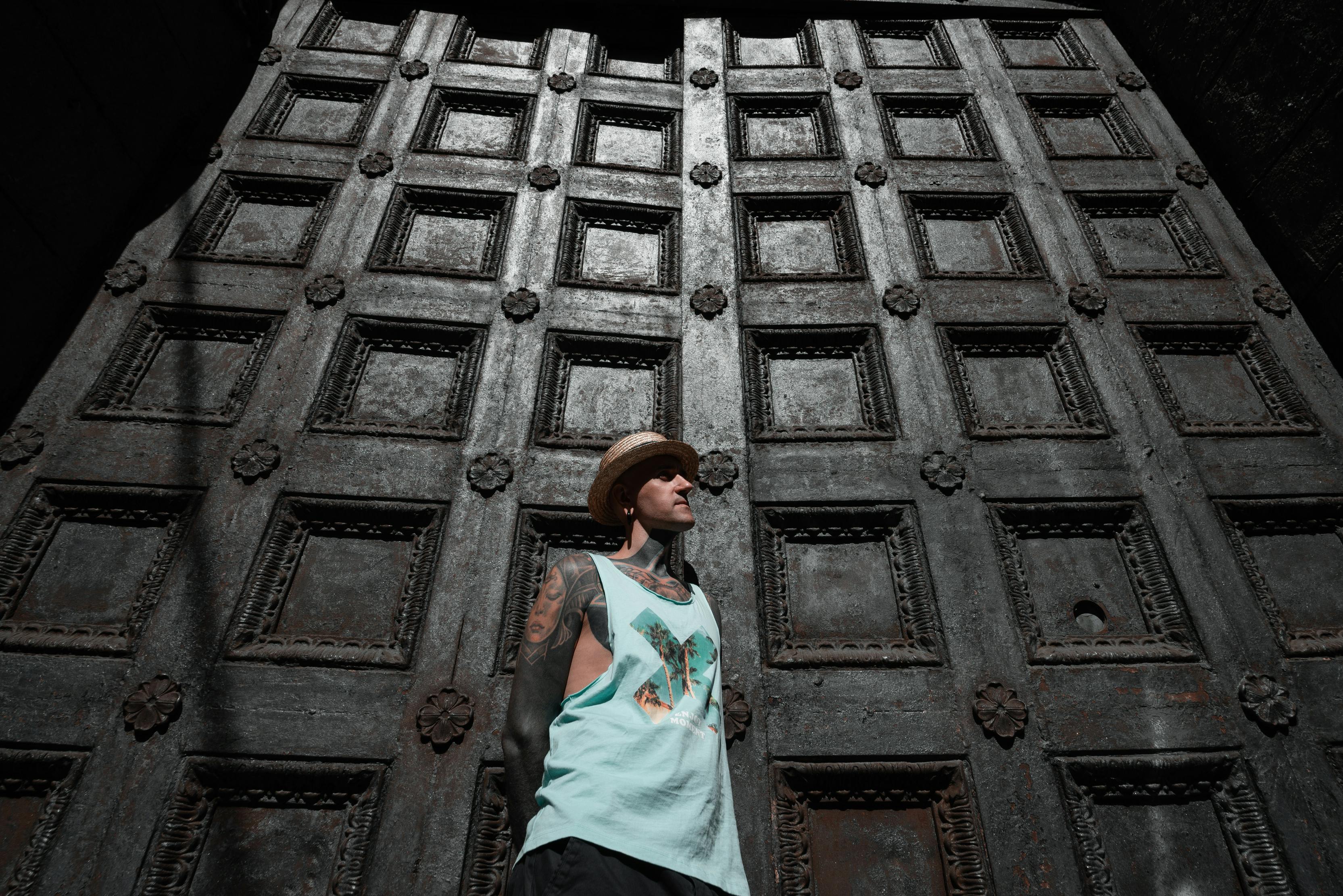 Young Man in Front of Wooden Door · Free Stock Photo