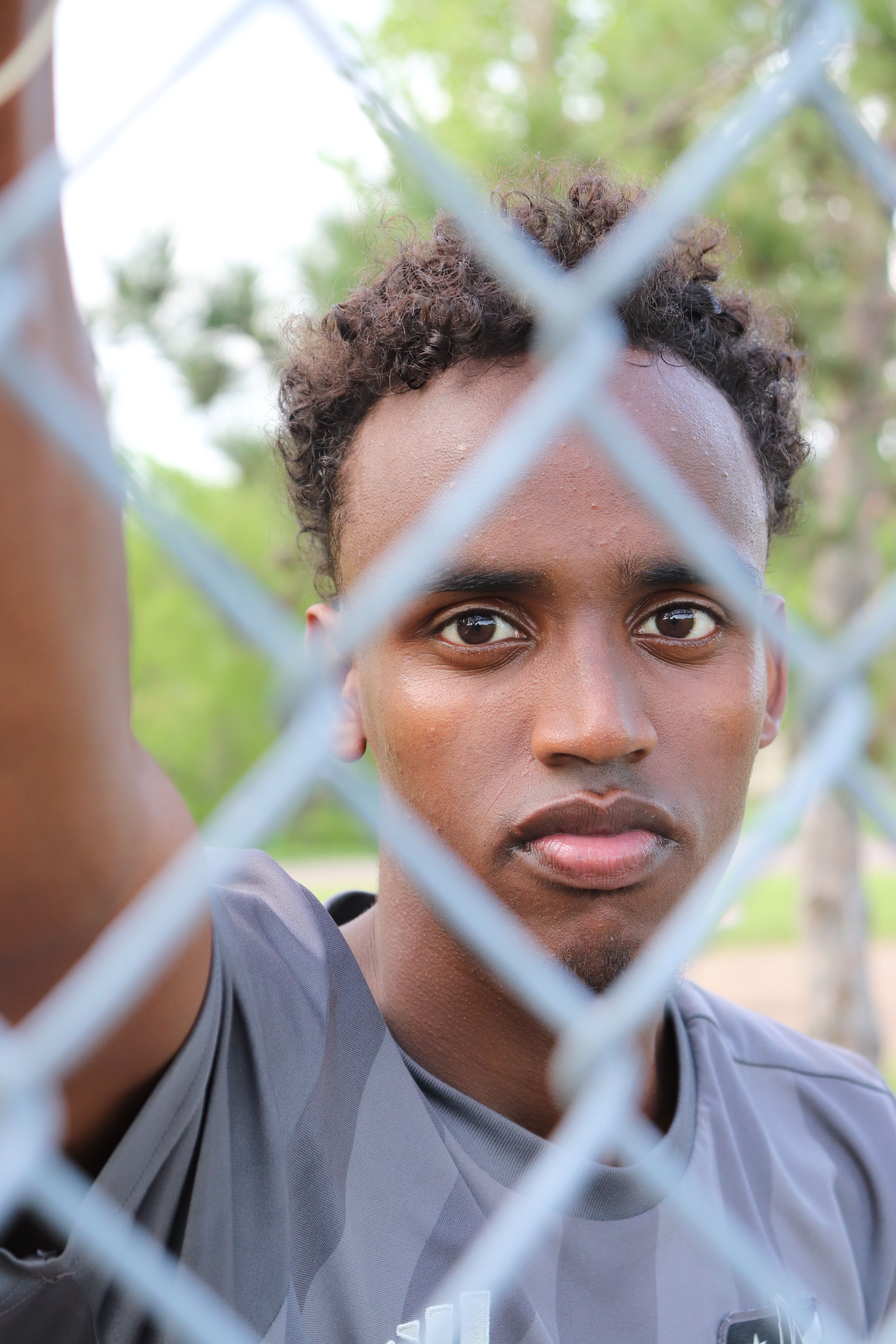 Young Man Behind a Steel Fence · Free Stock Photo
