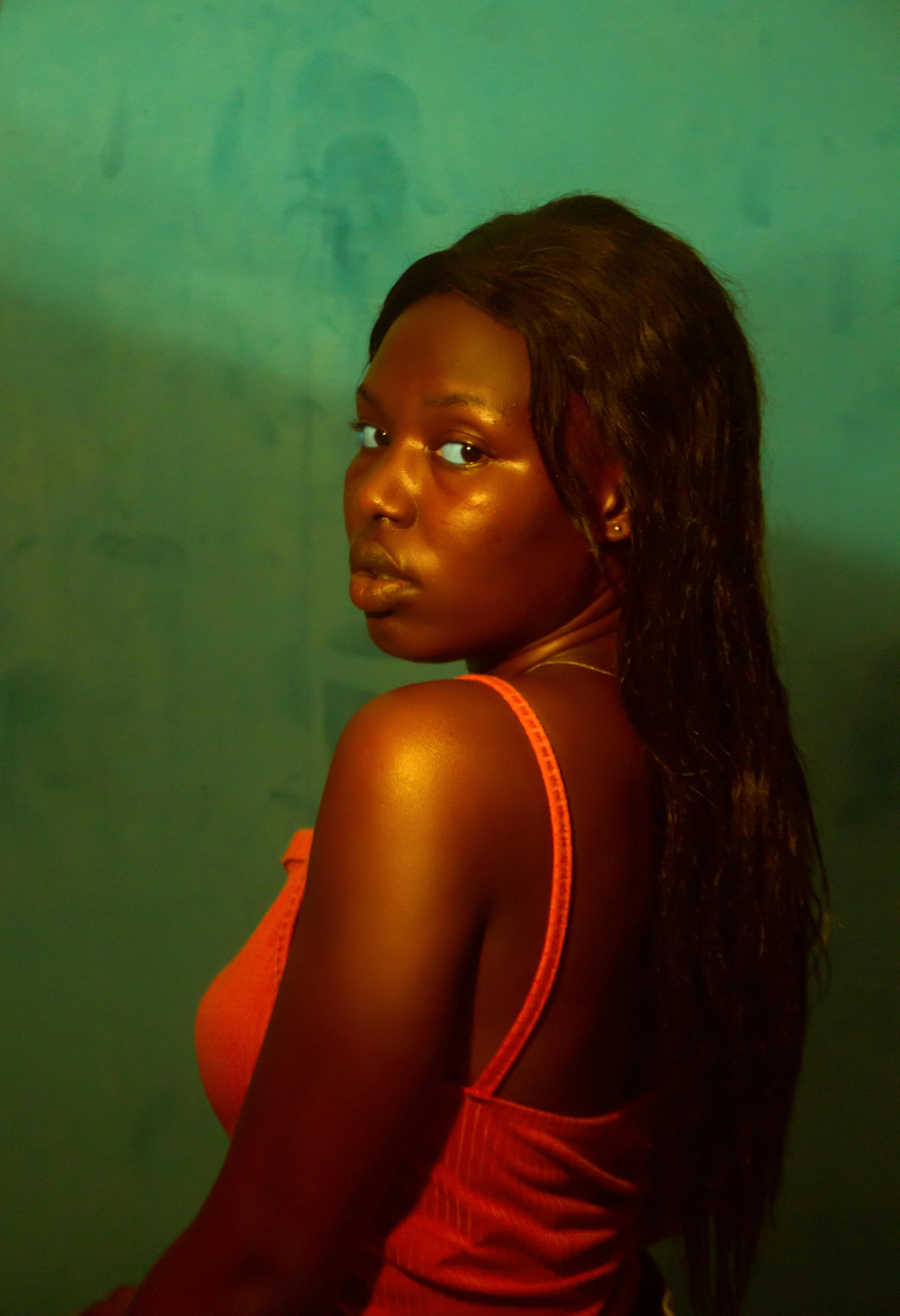 A Woman Wearing a Tank Top behind a Red Curtain · Free Stock Photo