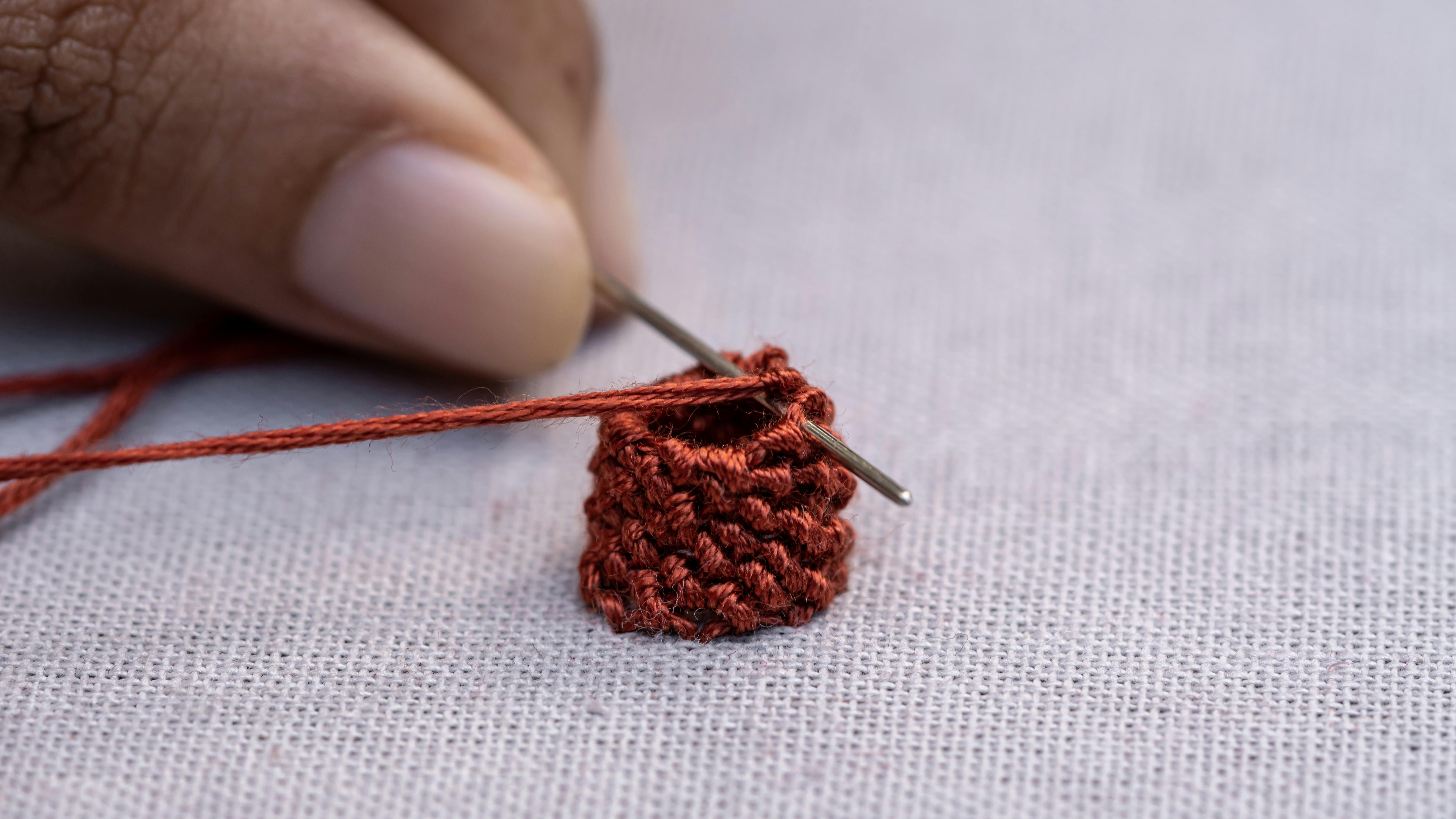 Hand and a Knitting Needle with a Thread · Free Stock Photo