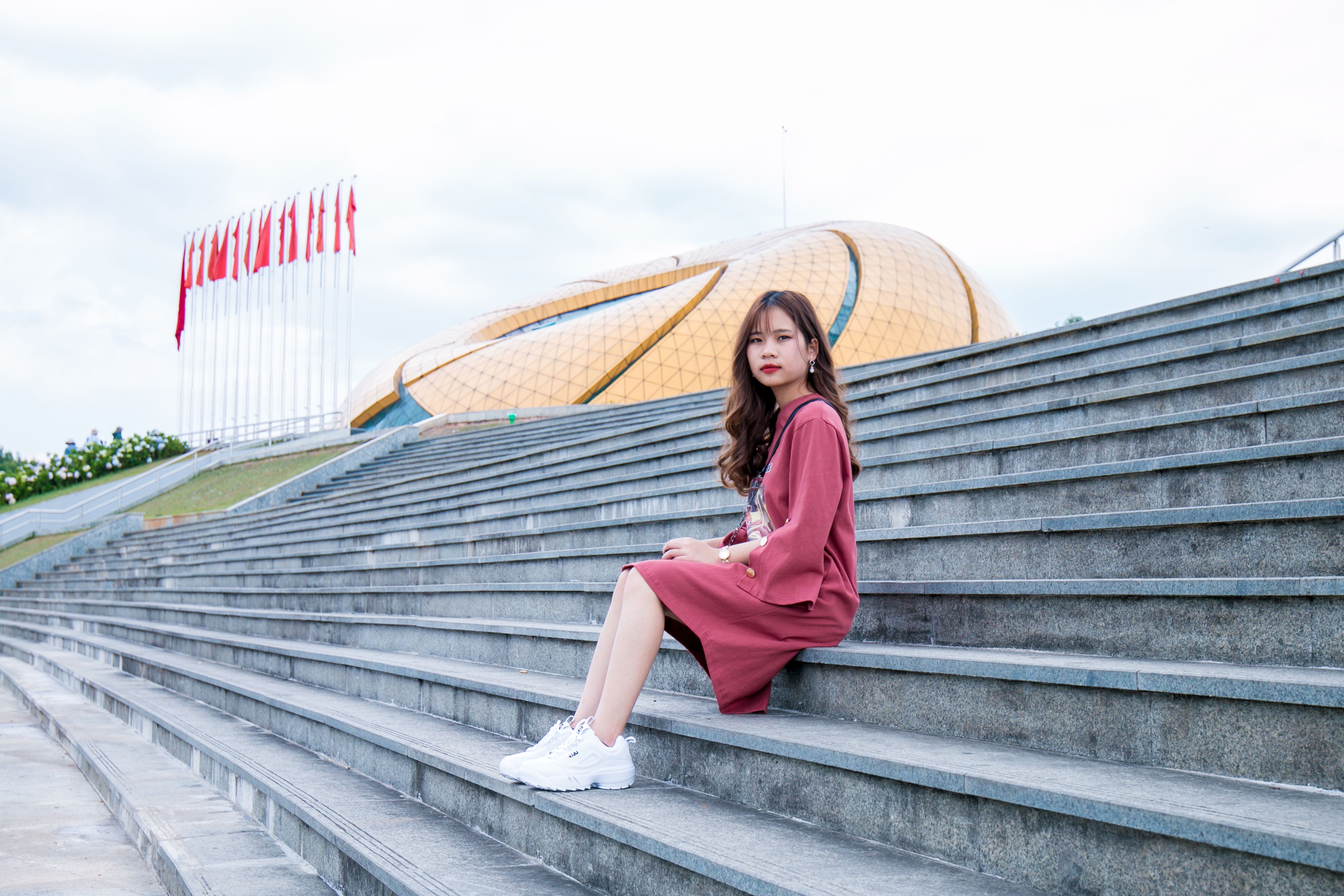 Woman in Blue Denim Jeans Sitting on Concrete Stairs · Free Stock Photo