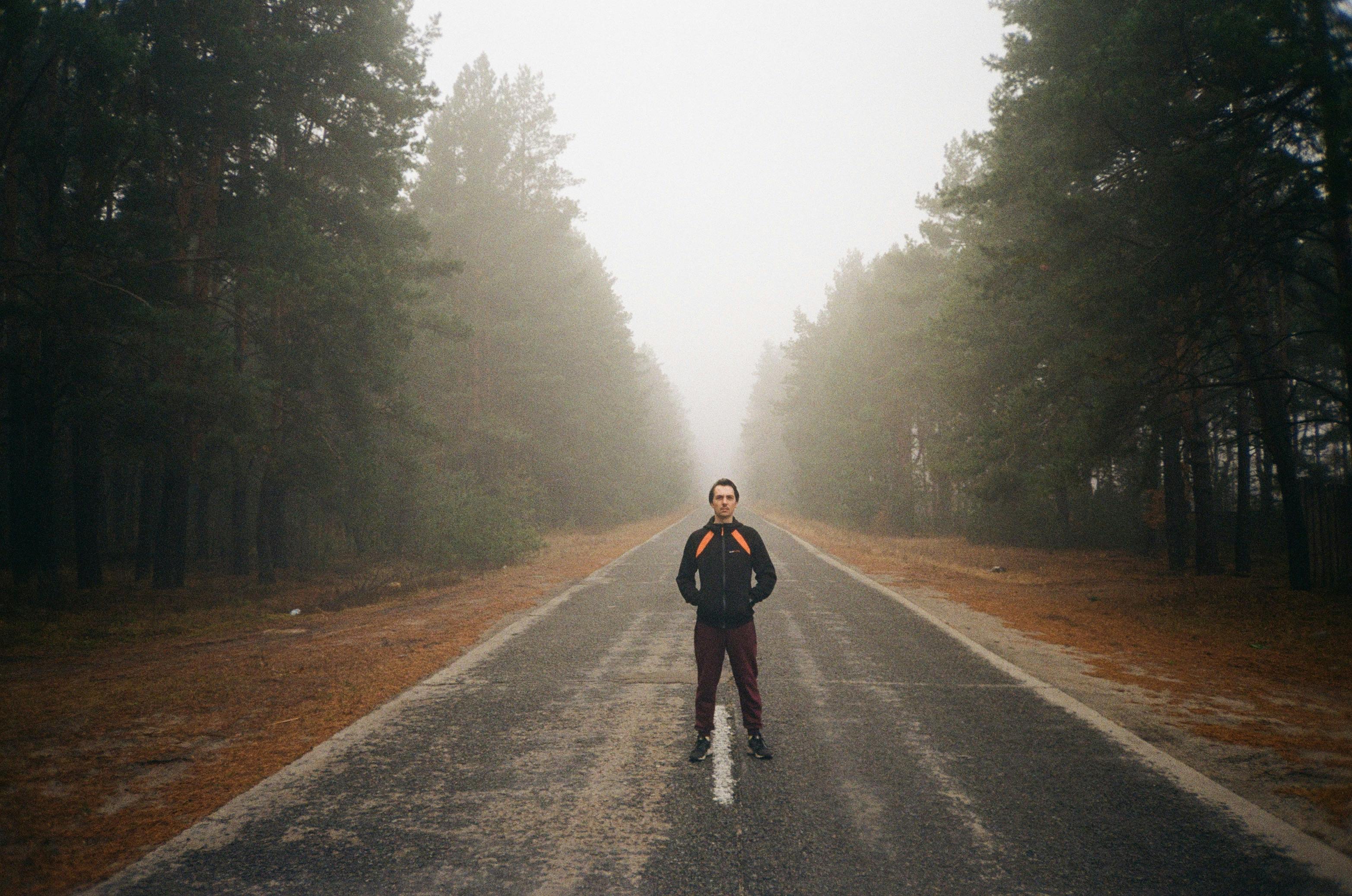 Man Standing on the Road During a Foggy Day · Free Stock Photo