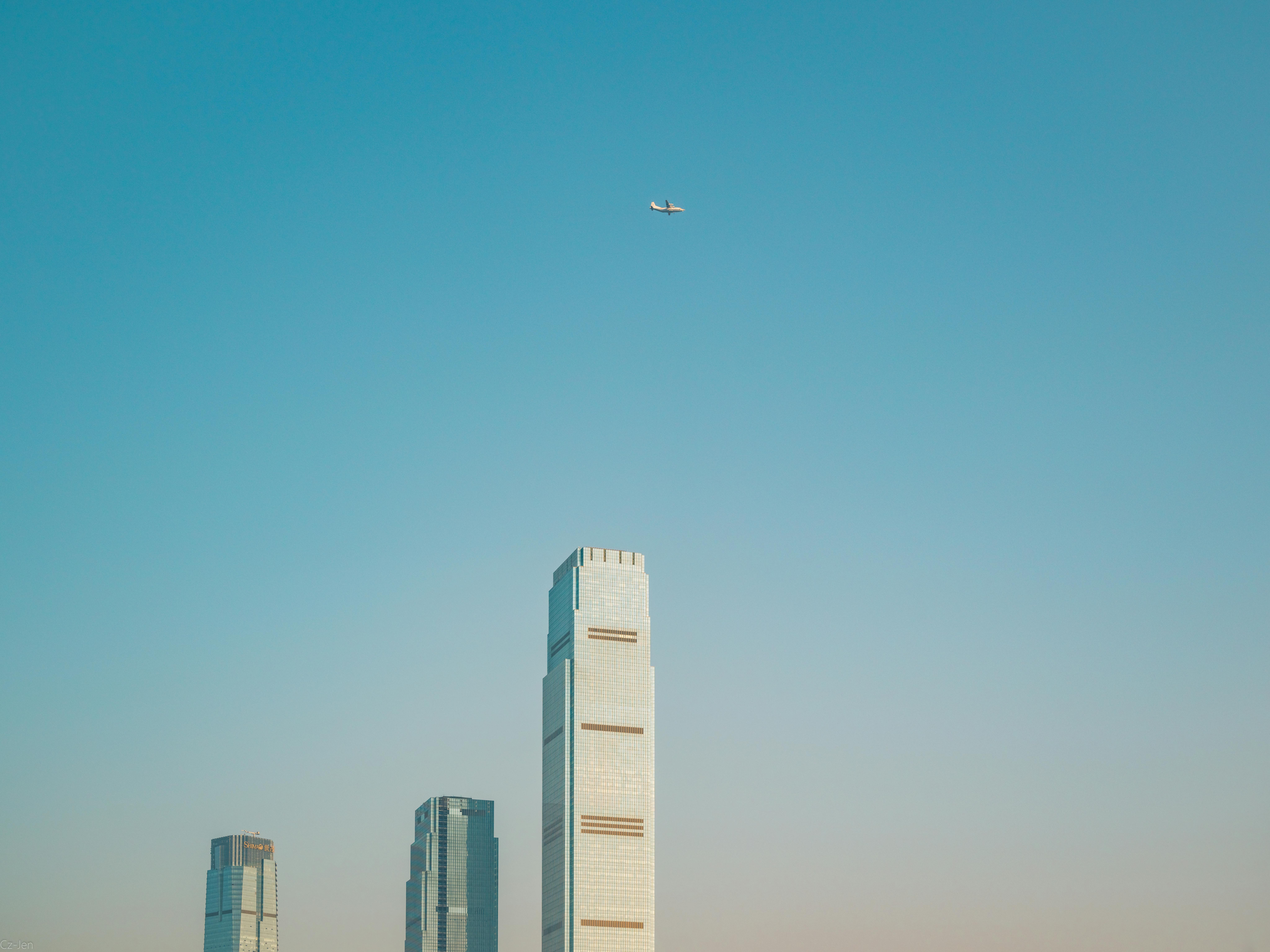 Low Angle Photo of Airplane Flying Over High-rise Buildings · Free ...