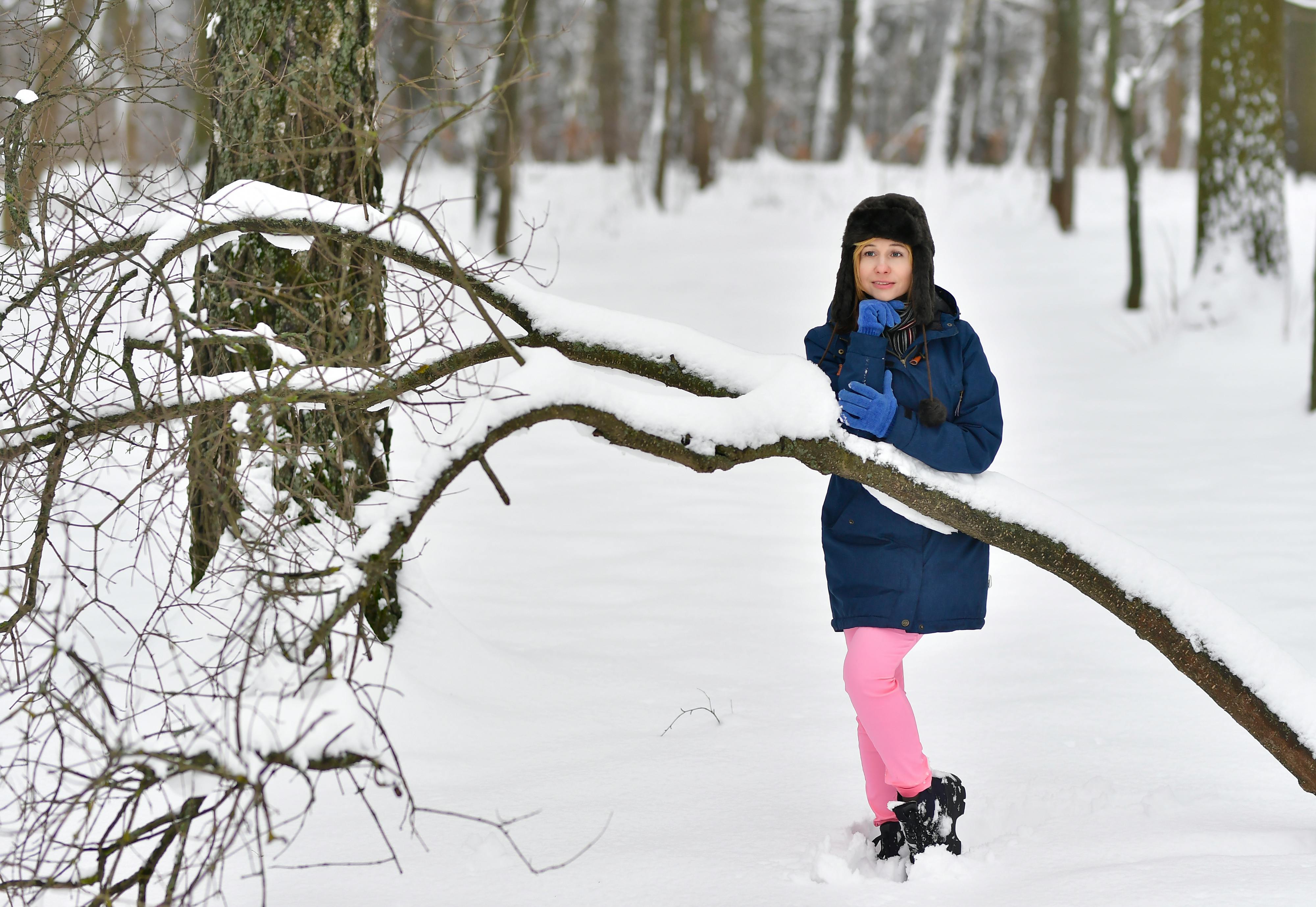 Woman in Blue Jacket Standing on Snow Covered Ground · Free Stock Photo