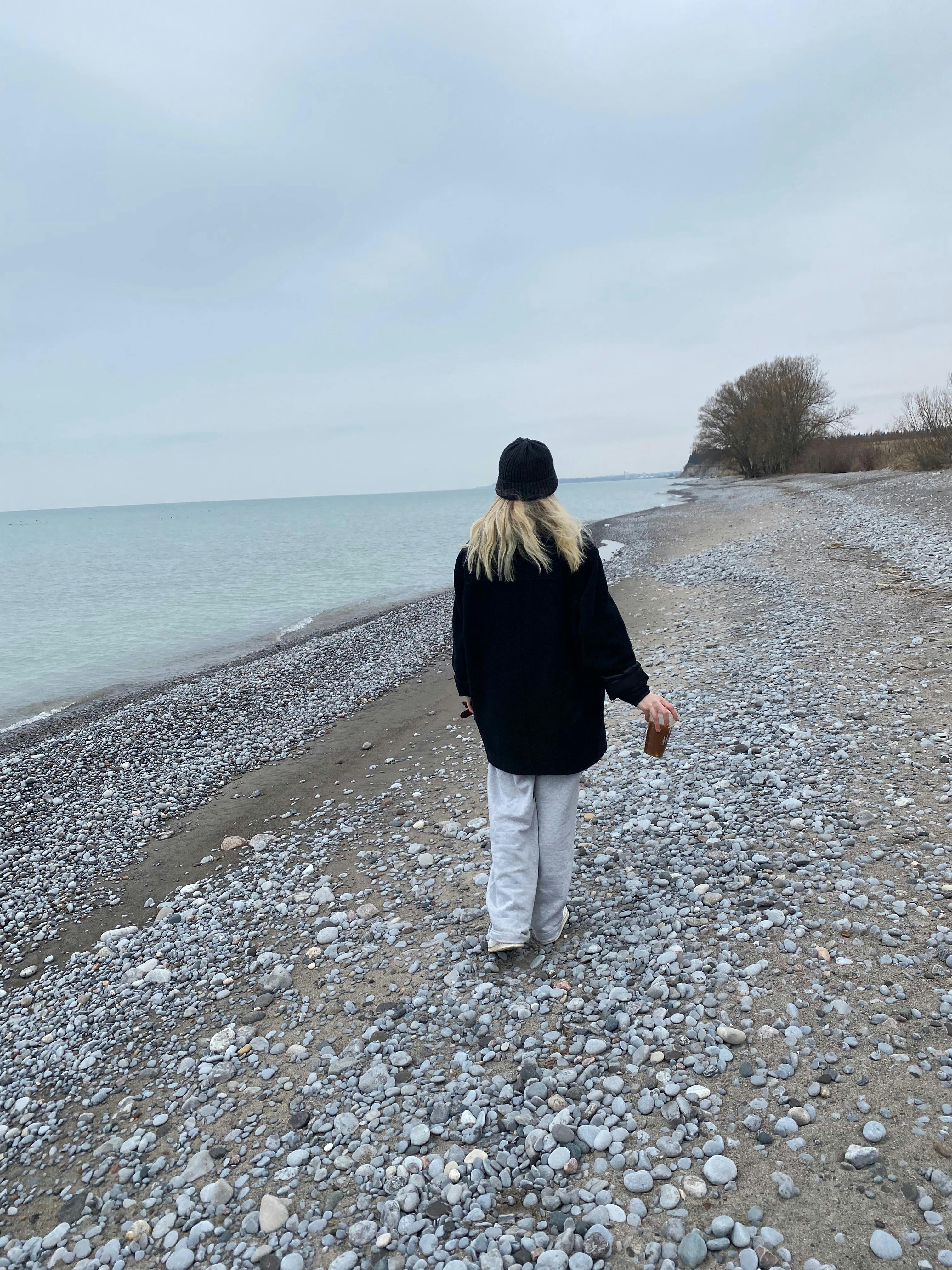 Back view Photo of Person Walking on Rocky Field · Free Stock Photo