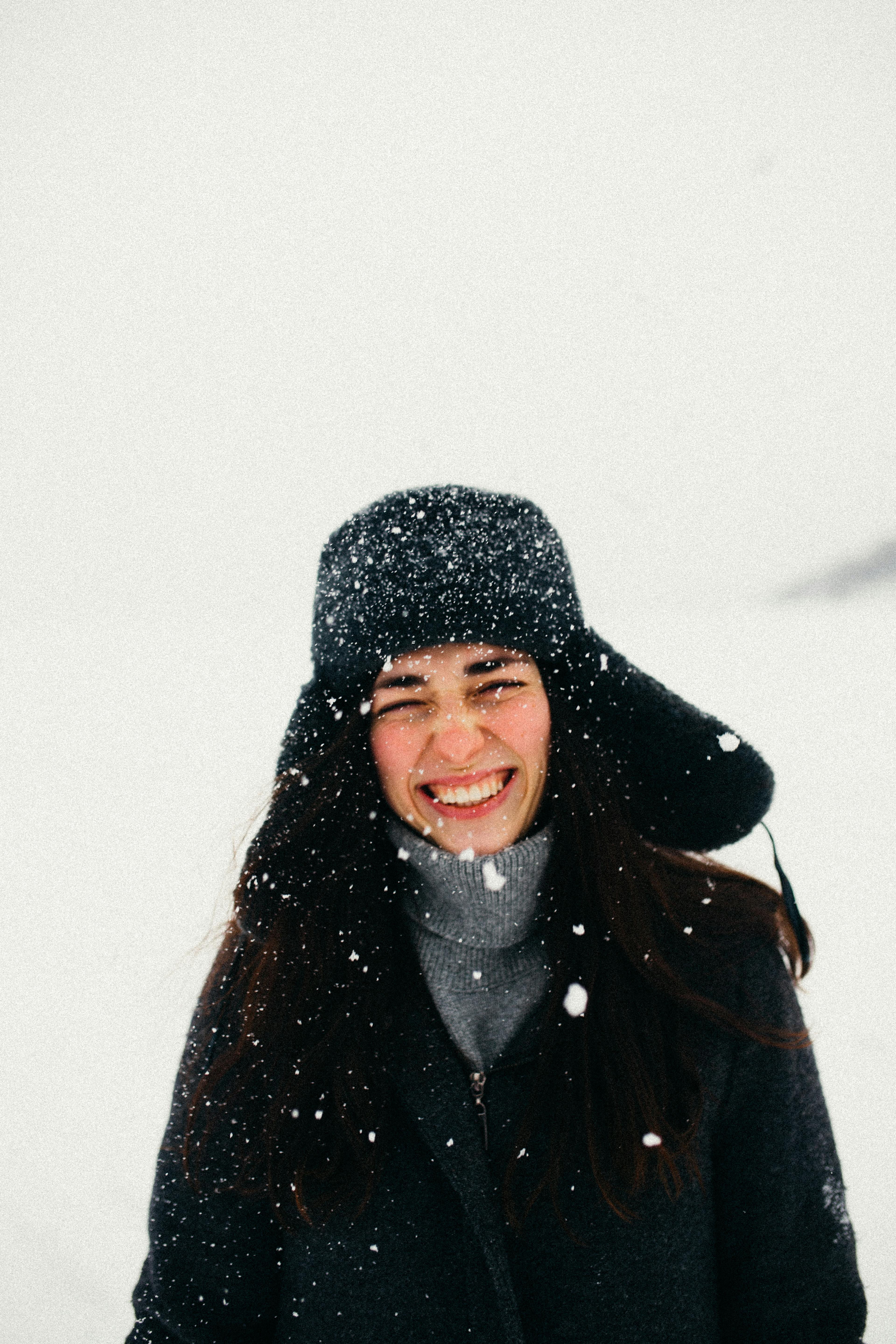 Woman Smiling in Falling Snow · Free Stock Photo