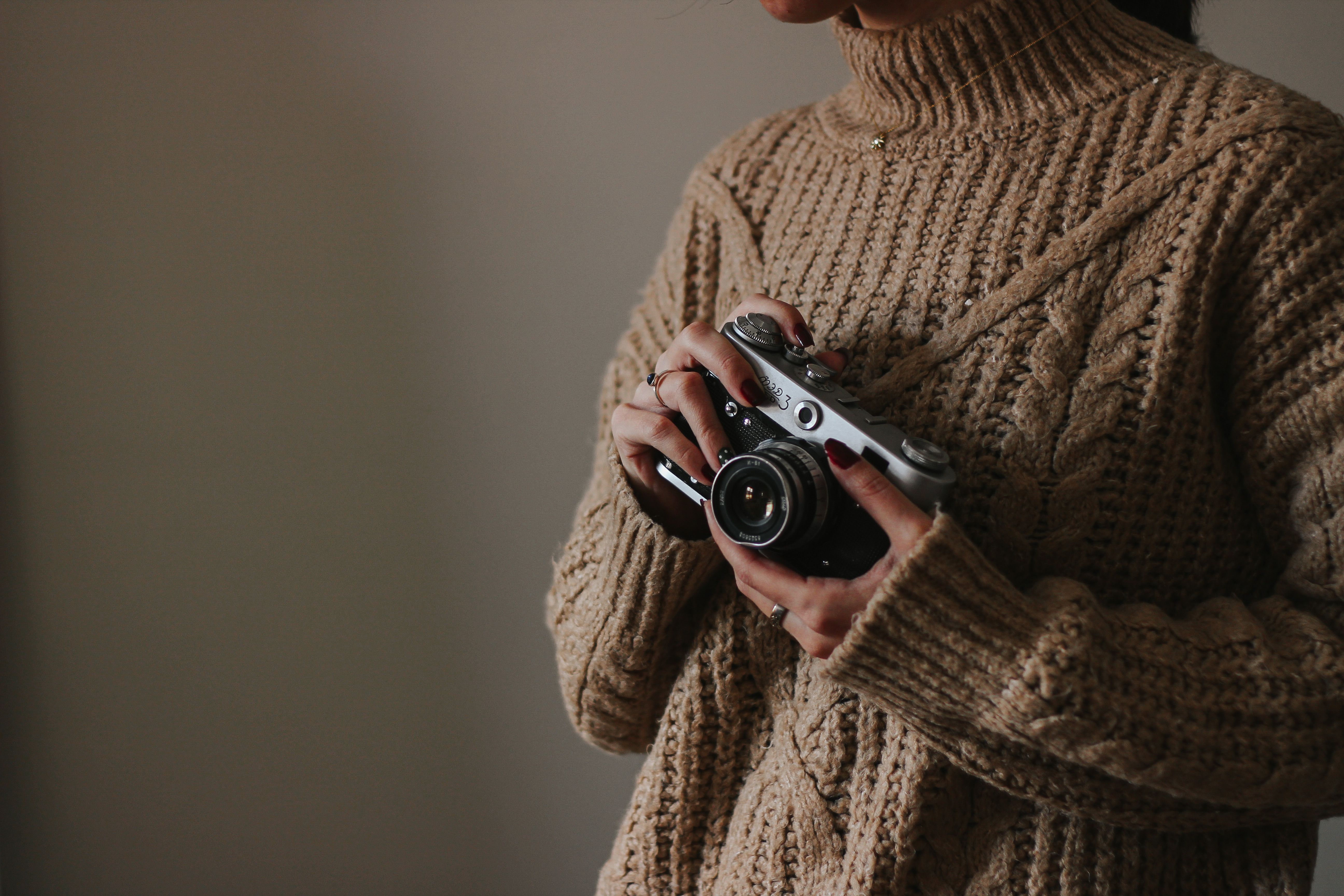 Person in Brown Knitted Sweater Holding a Camera · Free Stock Photo