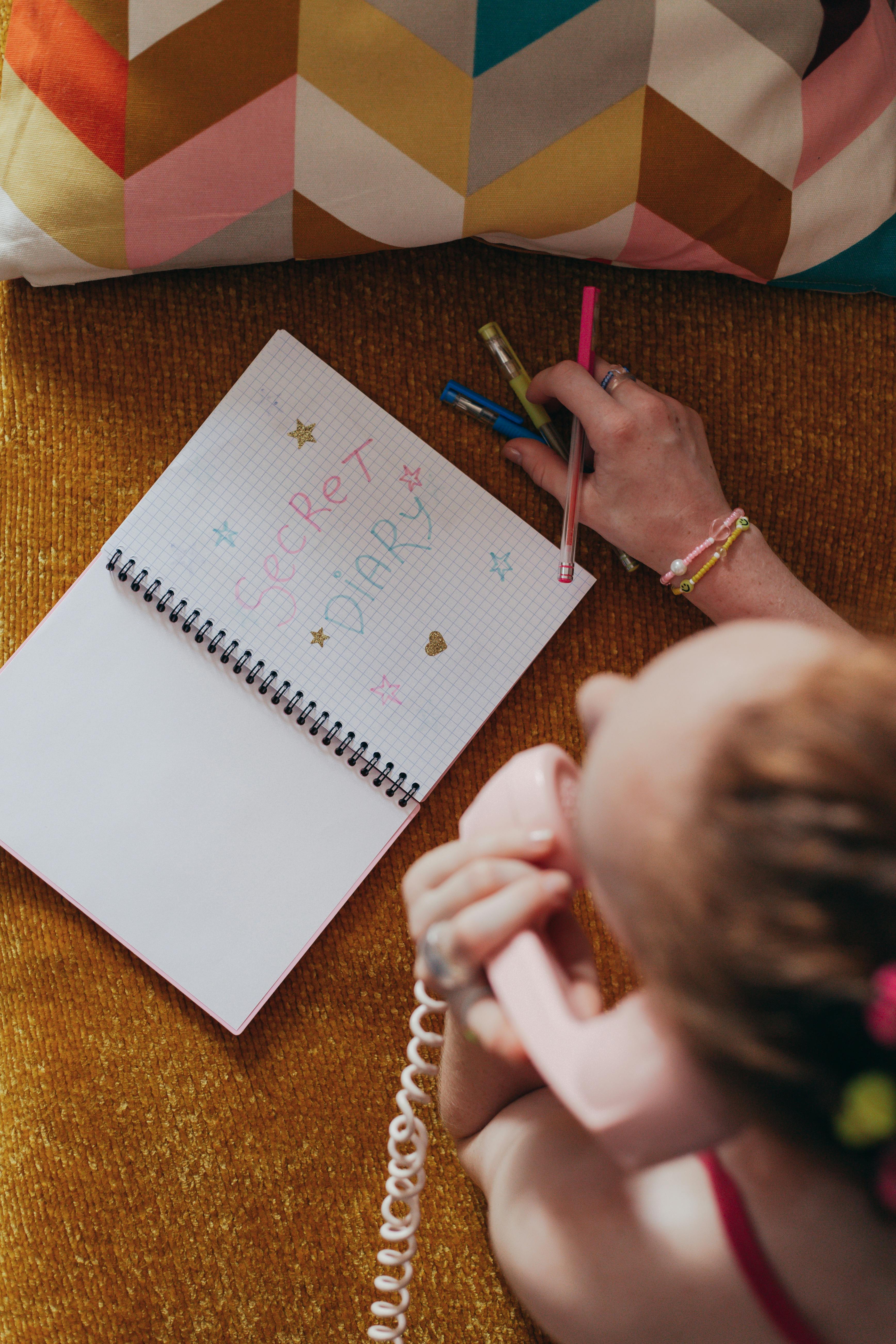Woman Having a Telephone Call while Writing on Her Diary · Free Stock Photo