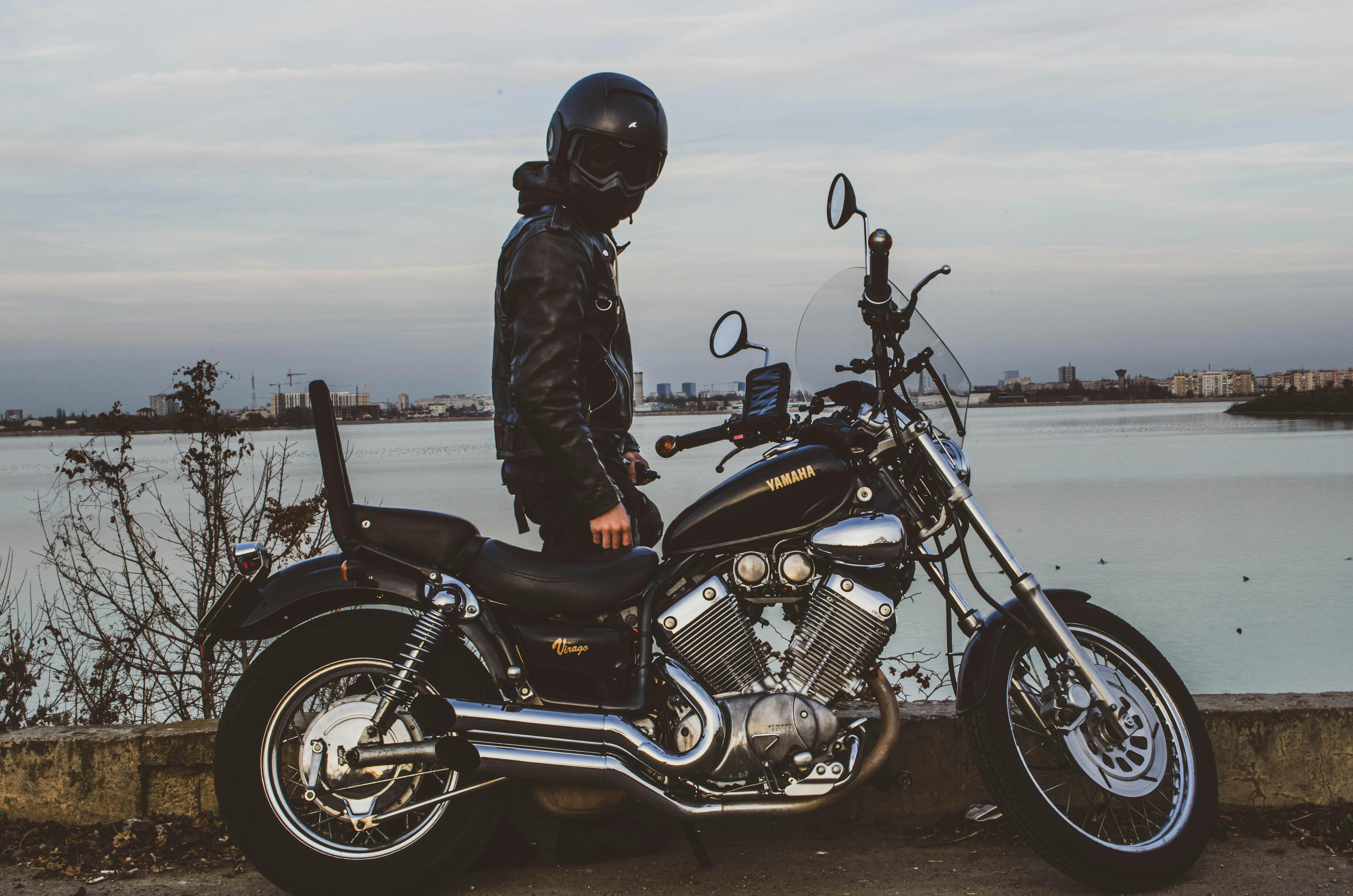 Man Riding a Motorcycle Wearing a Black Helmet and Leather Jacket ...