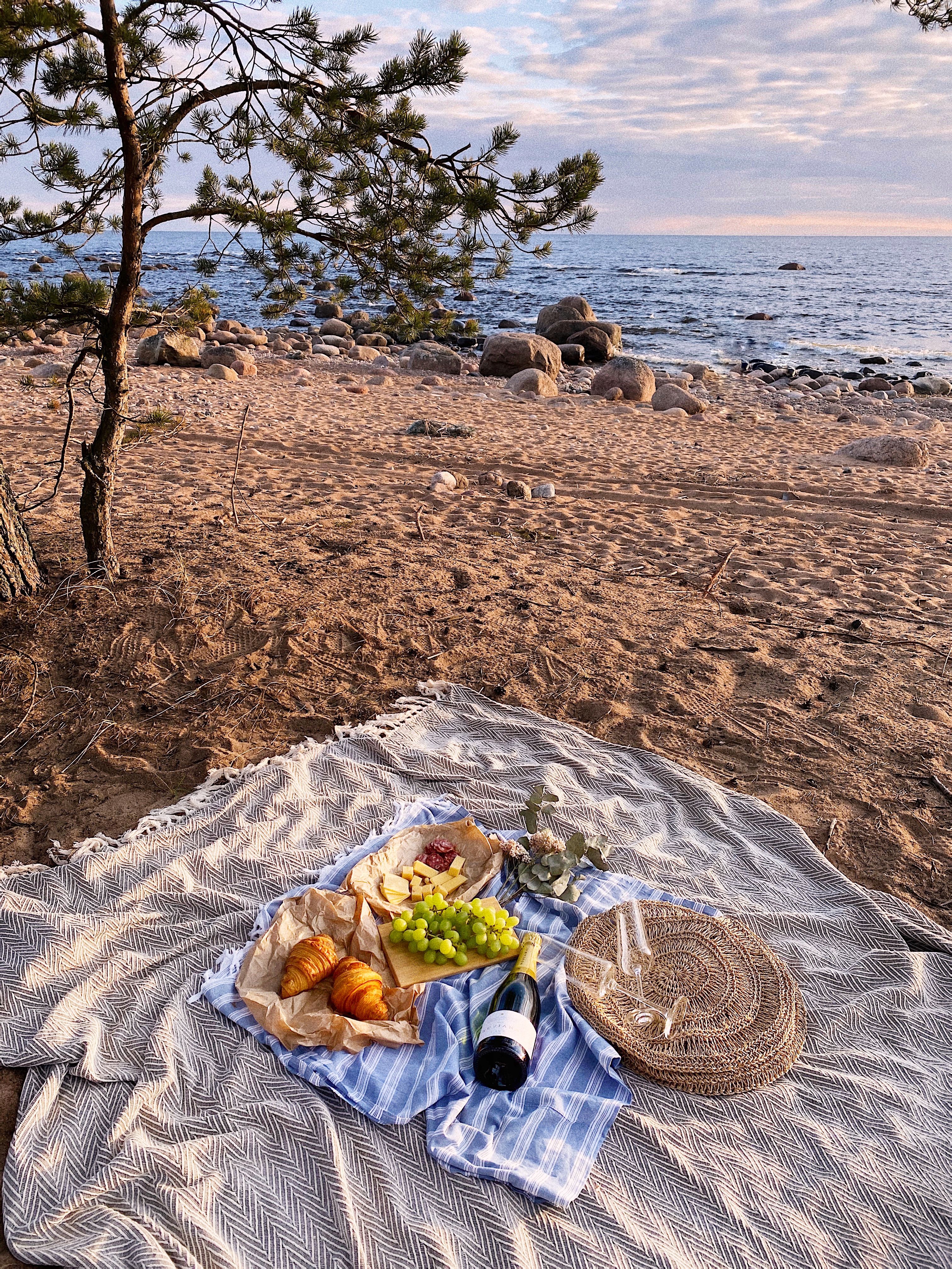 Picnic Blanket with Food on Brown Sand Near Body of Water · Free Stock ...