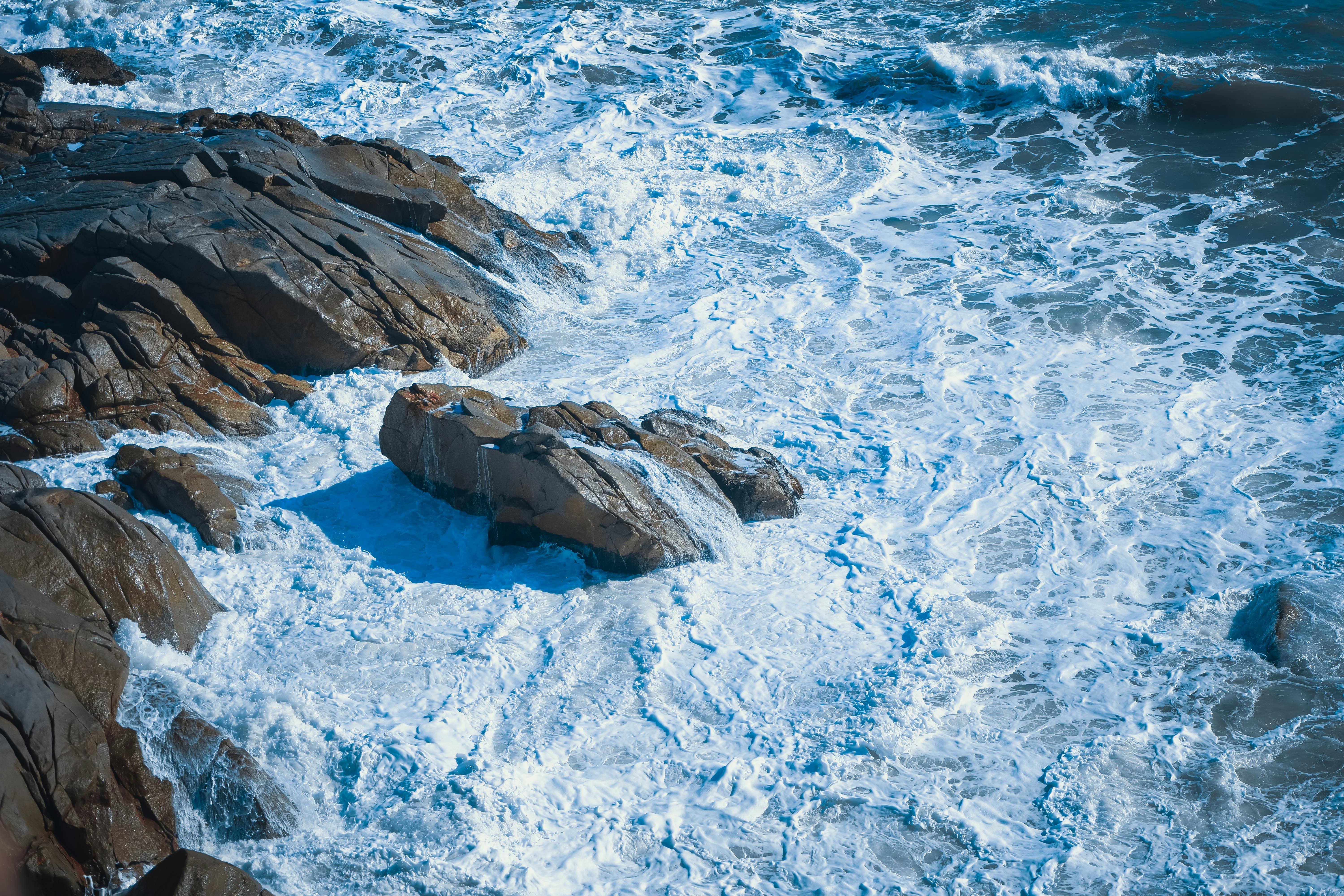 Photo of Rock Formation Near Seashore Under Blue Sky · Free Stock Photo