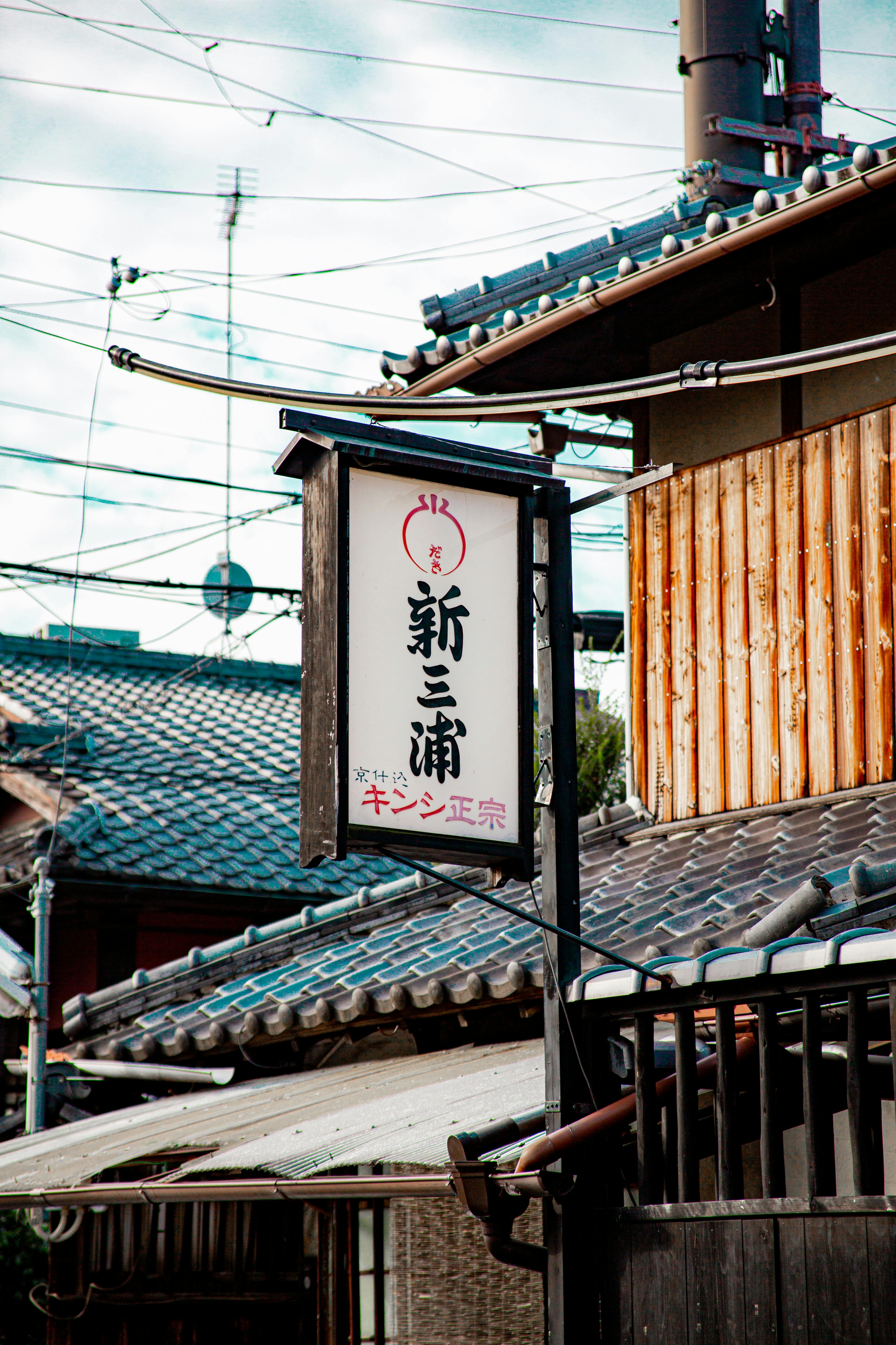 A Business Signage Hanging on a Wooden Pole Outside a Building · Free ...