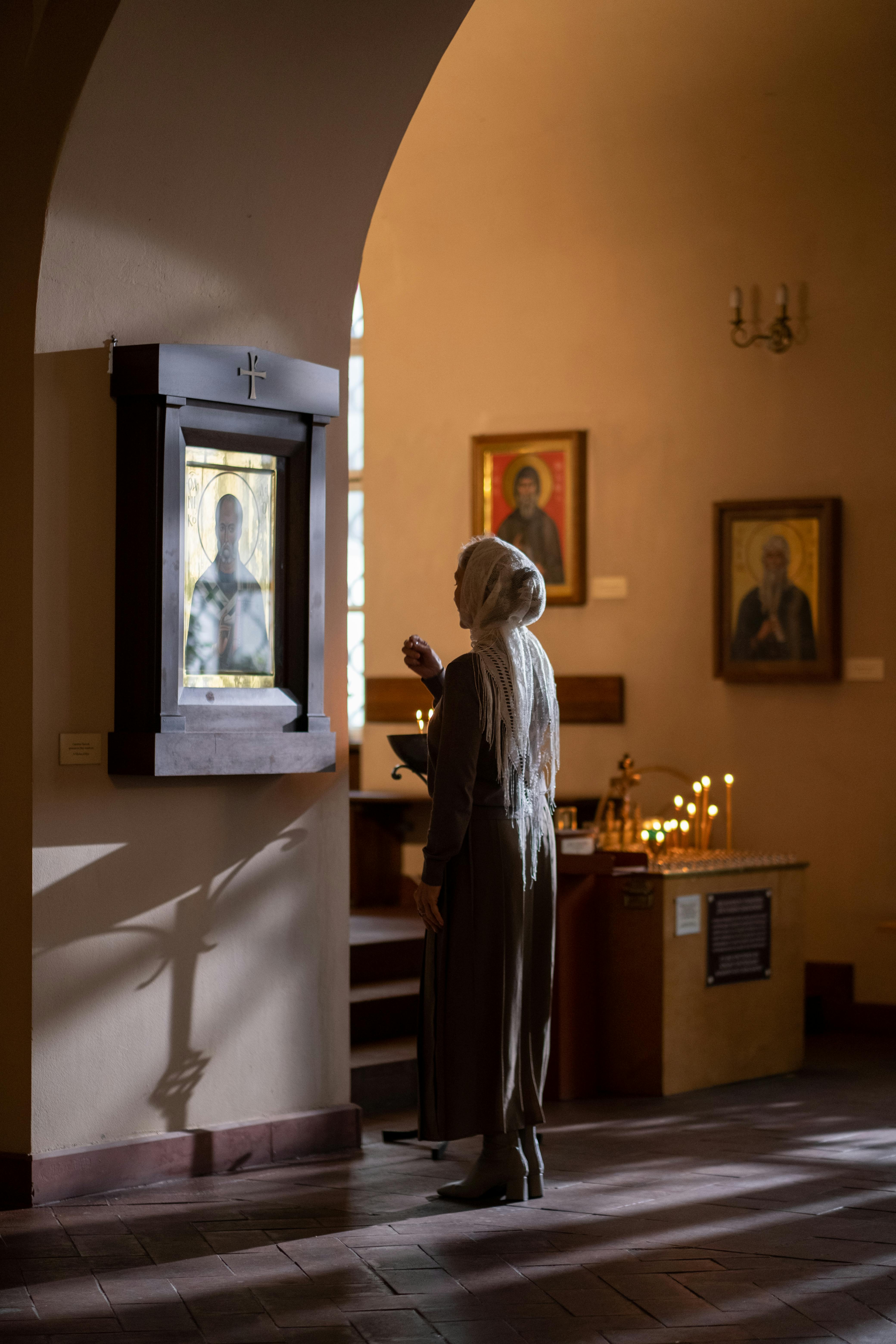 Woman Wearing Head Covering Praying Before Icon · Free Stock Photo