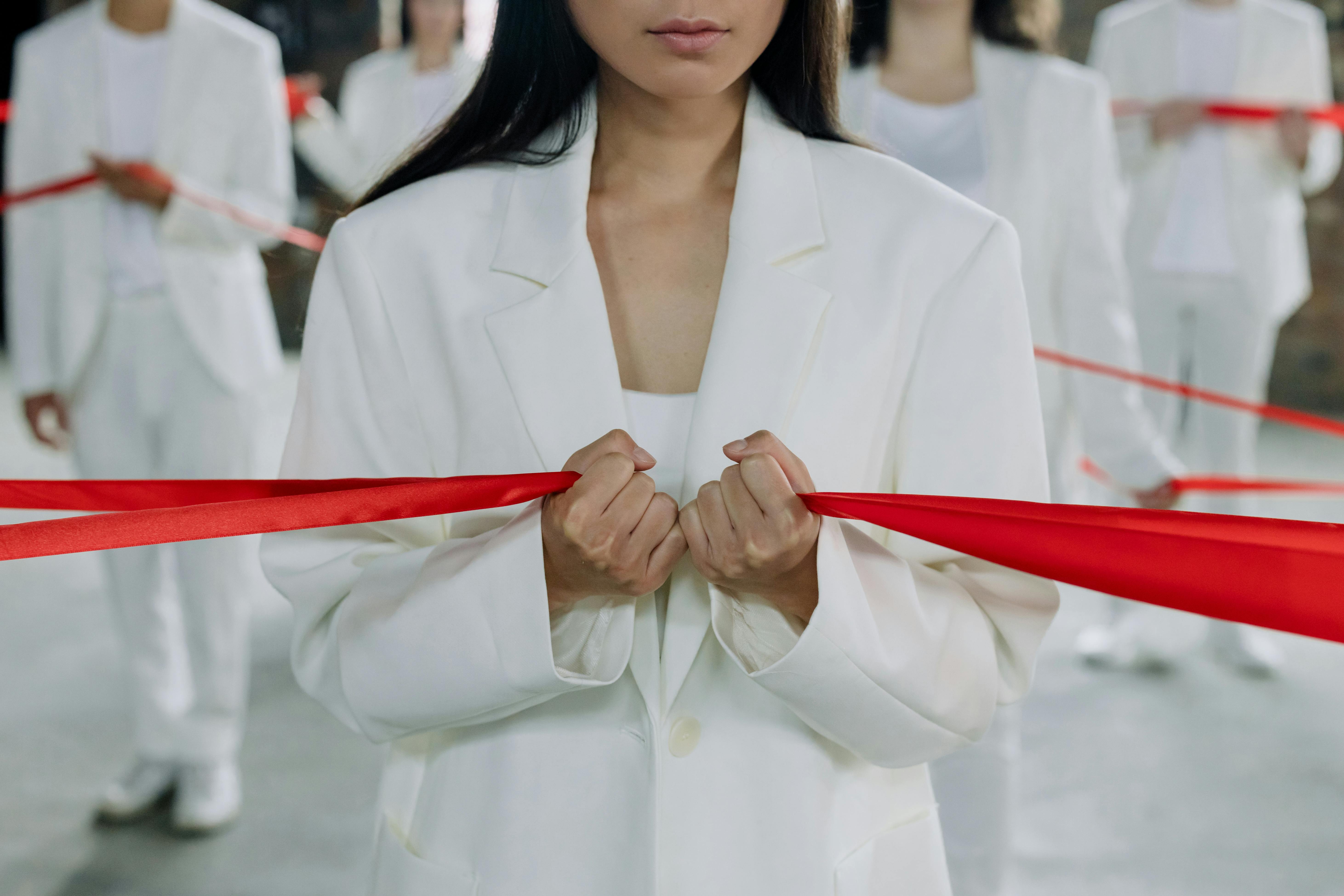 Woman in White Suit Holding Red Ribbon · Free Stock Photo