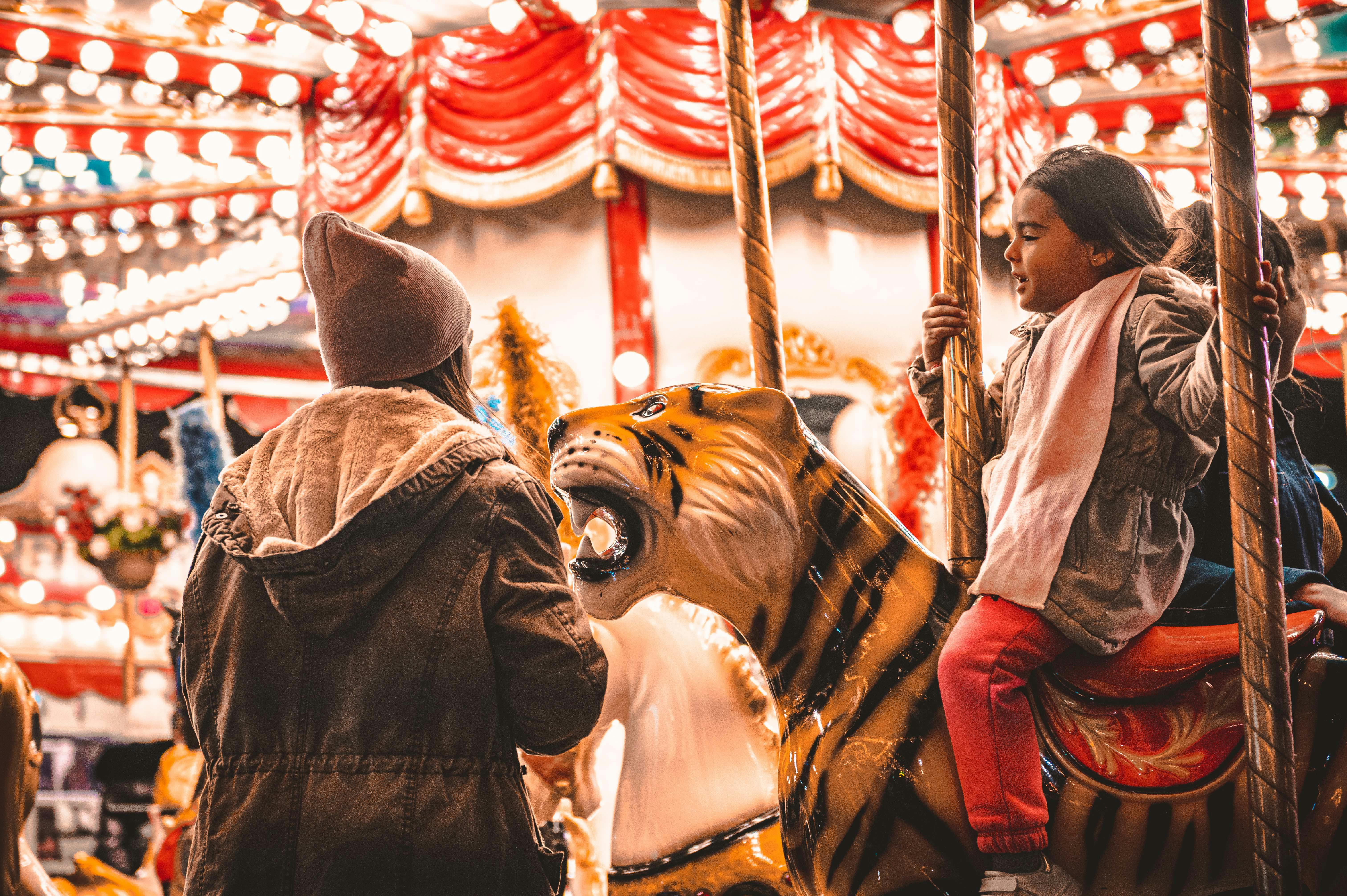 A Back View of a Woman Looking at the Girl Riding on Carousel · Free ...
