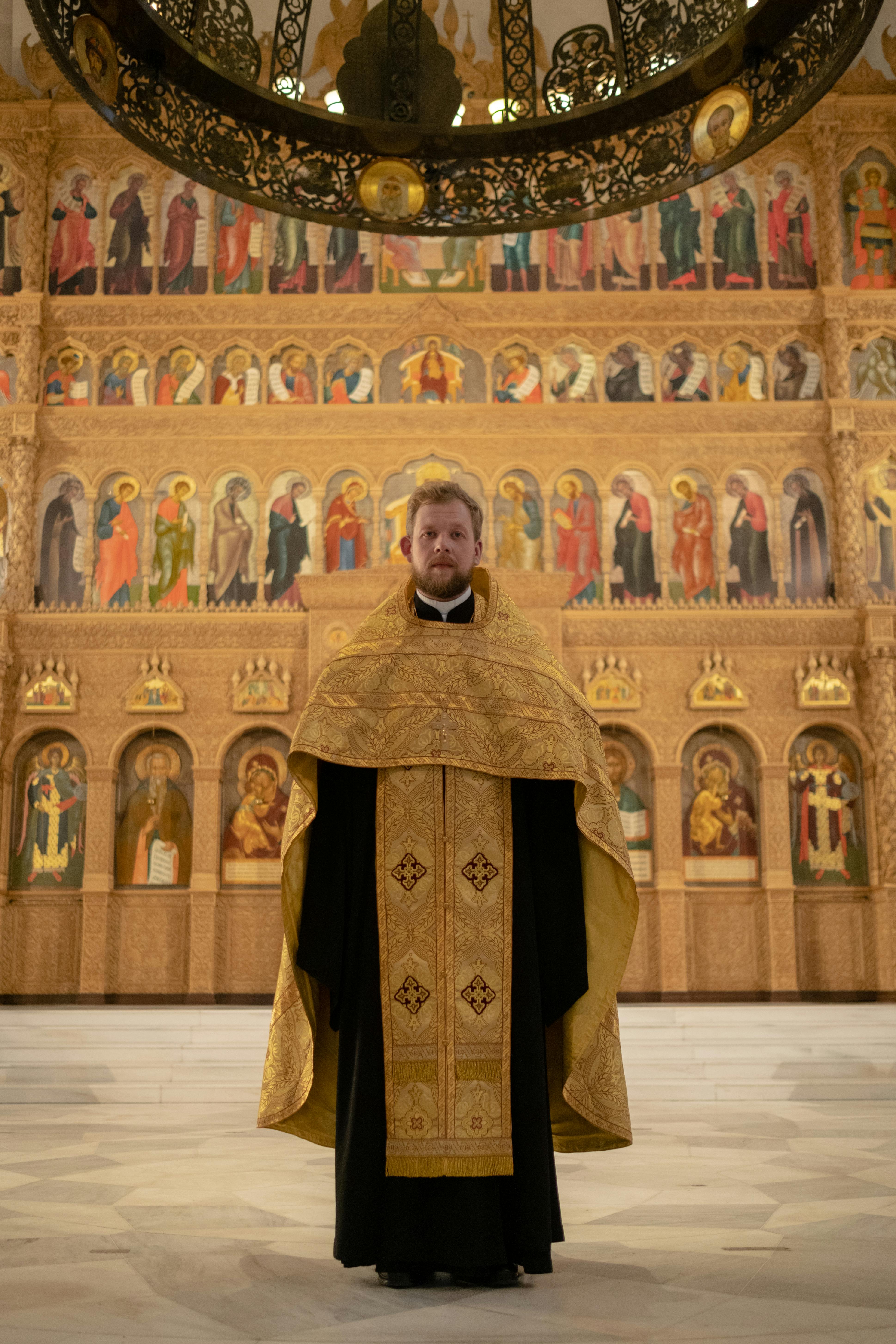 Priest standing near Iconostasis · Free Stock Photo
