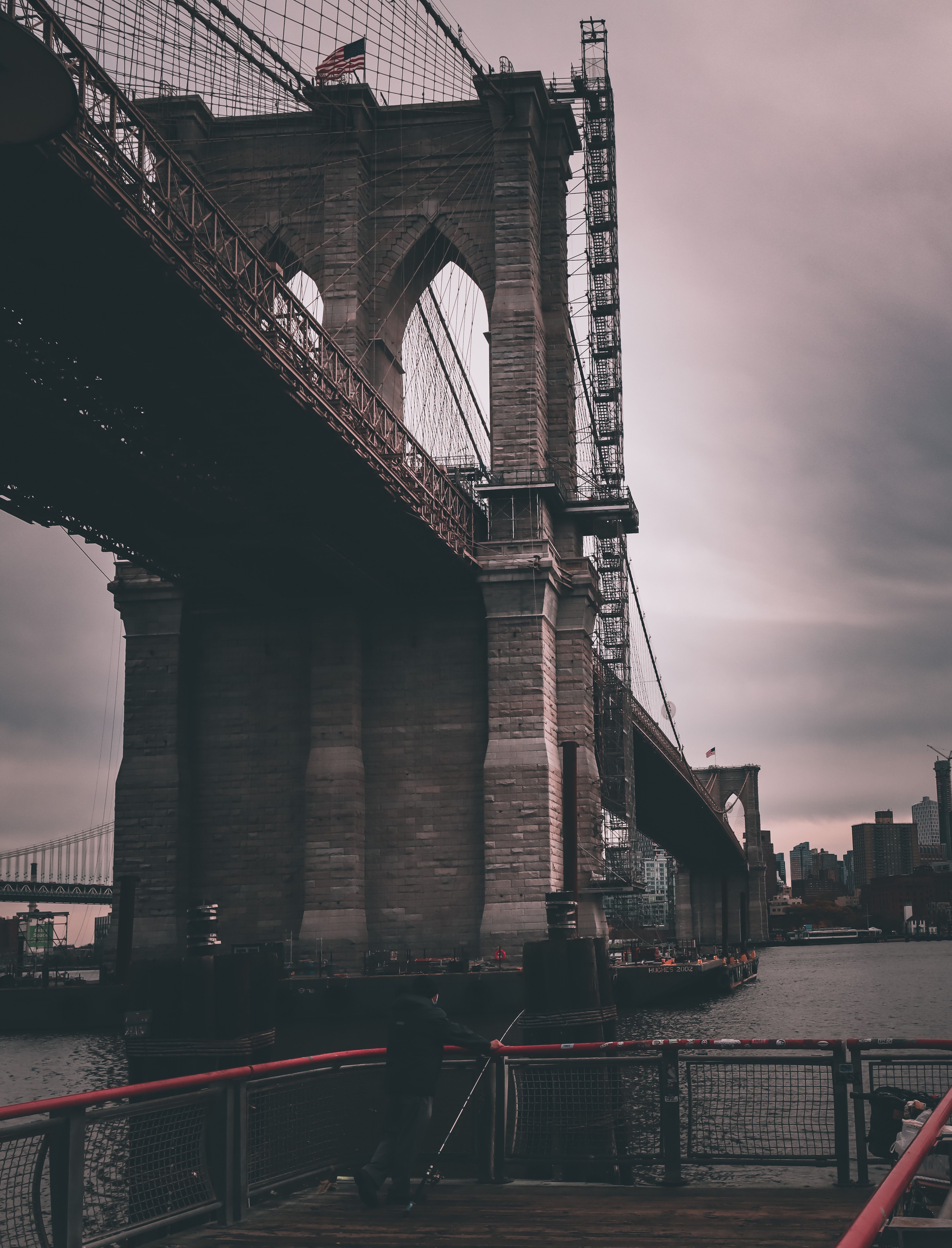 Man Standing Under Brooklyn Bridge · Free Stock Photo