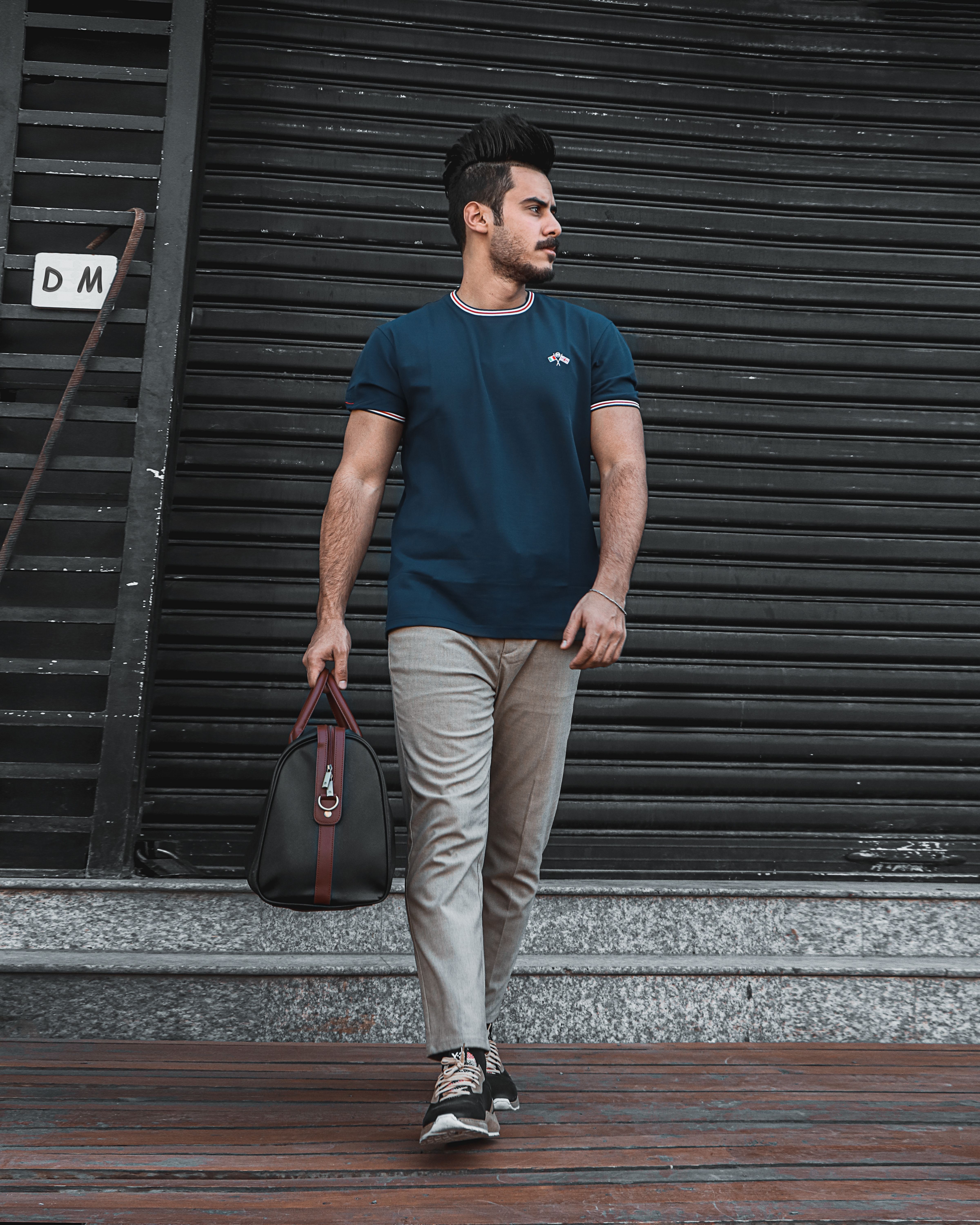 Stylish Man carrying a Leather Bag while walking · Free Stock Photo