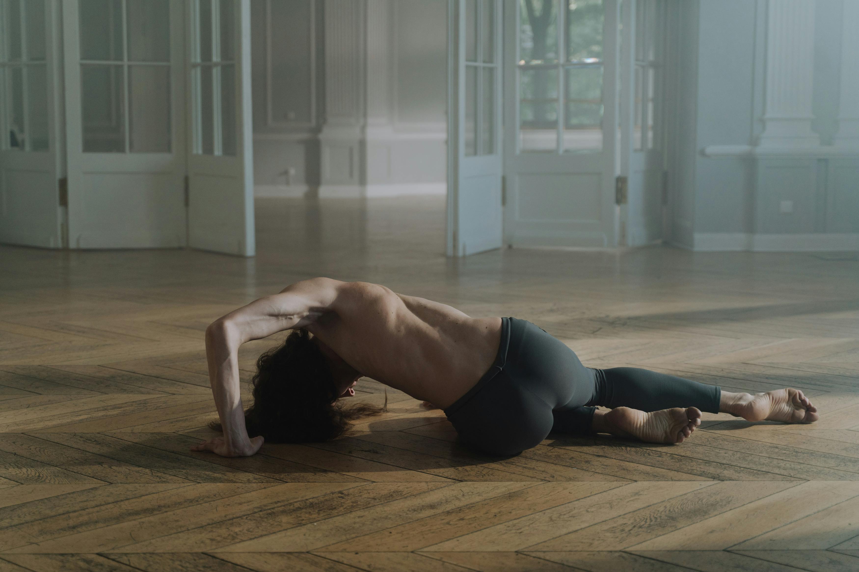 A Shirtless Man Dancing Gracefully on the Floor · Free Stock Photo