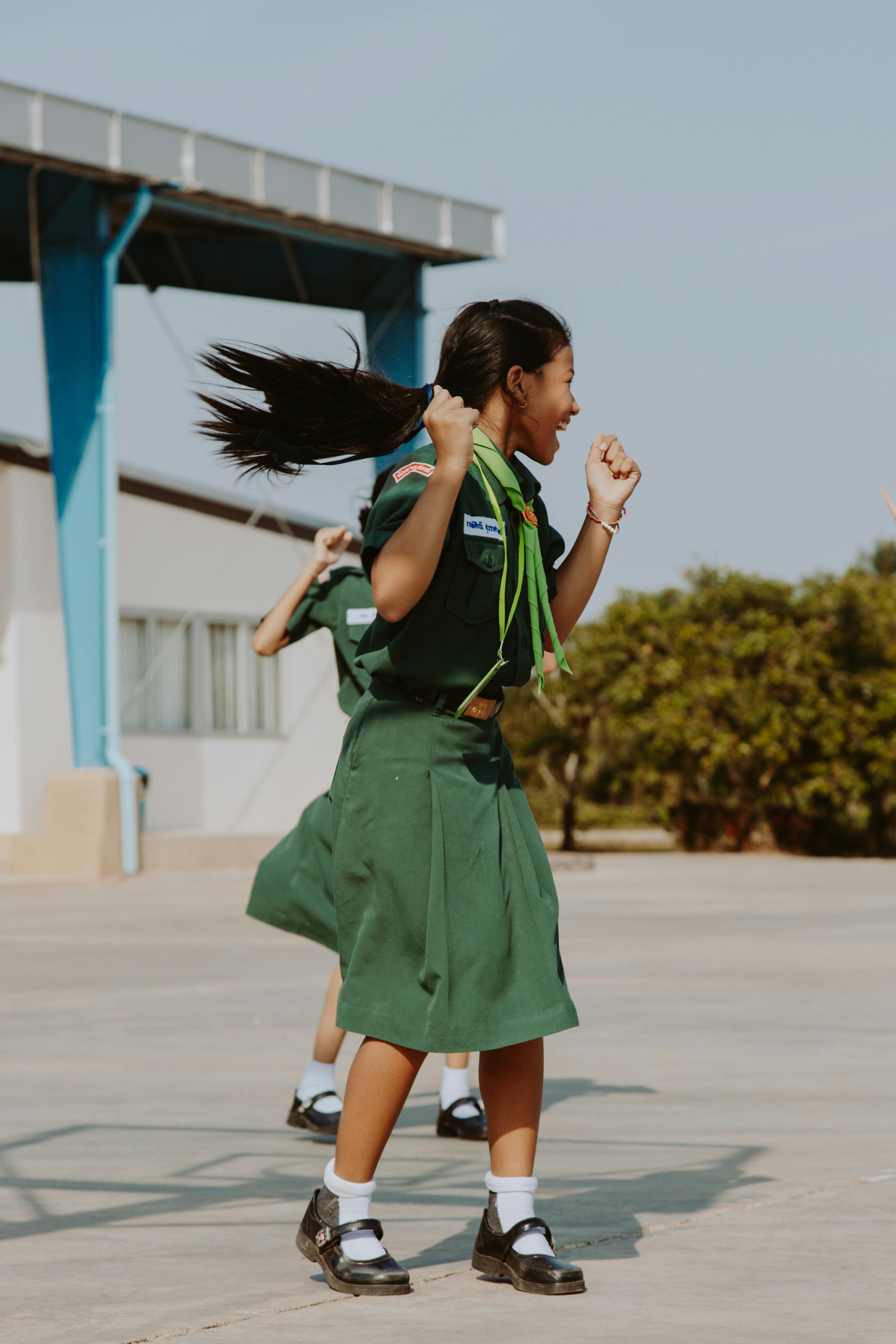 Girl in School Uniform Throwing Her Backpack · Free Stock Photo
