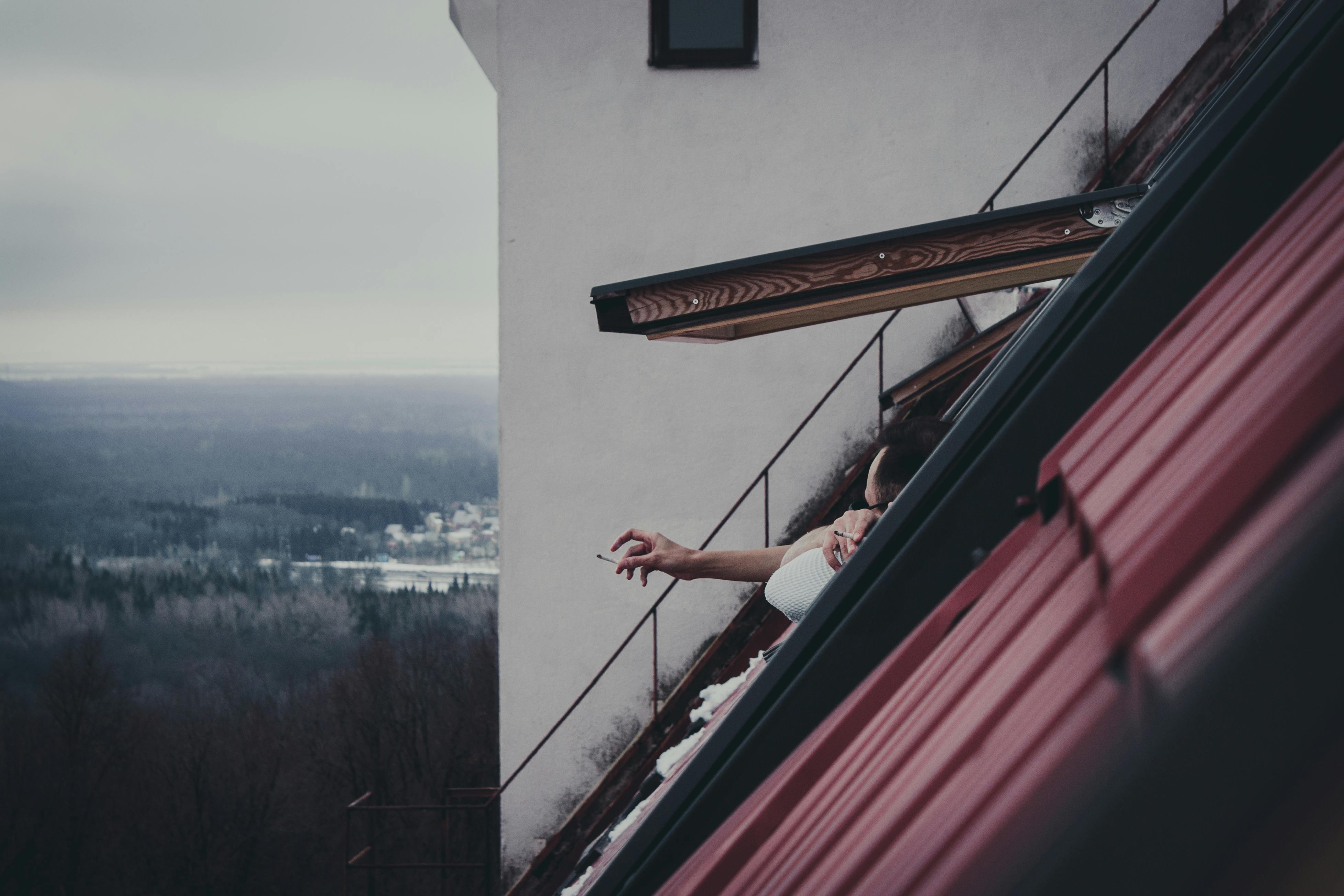 People with Cigarettes Looking at View from a Roof Window · Free Stock ...