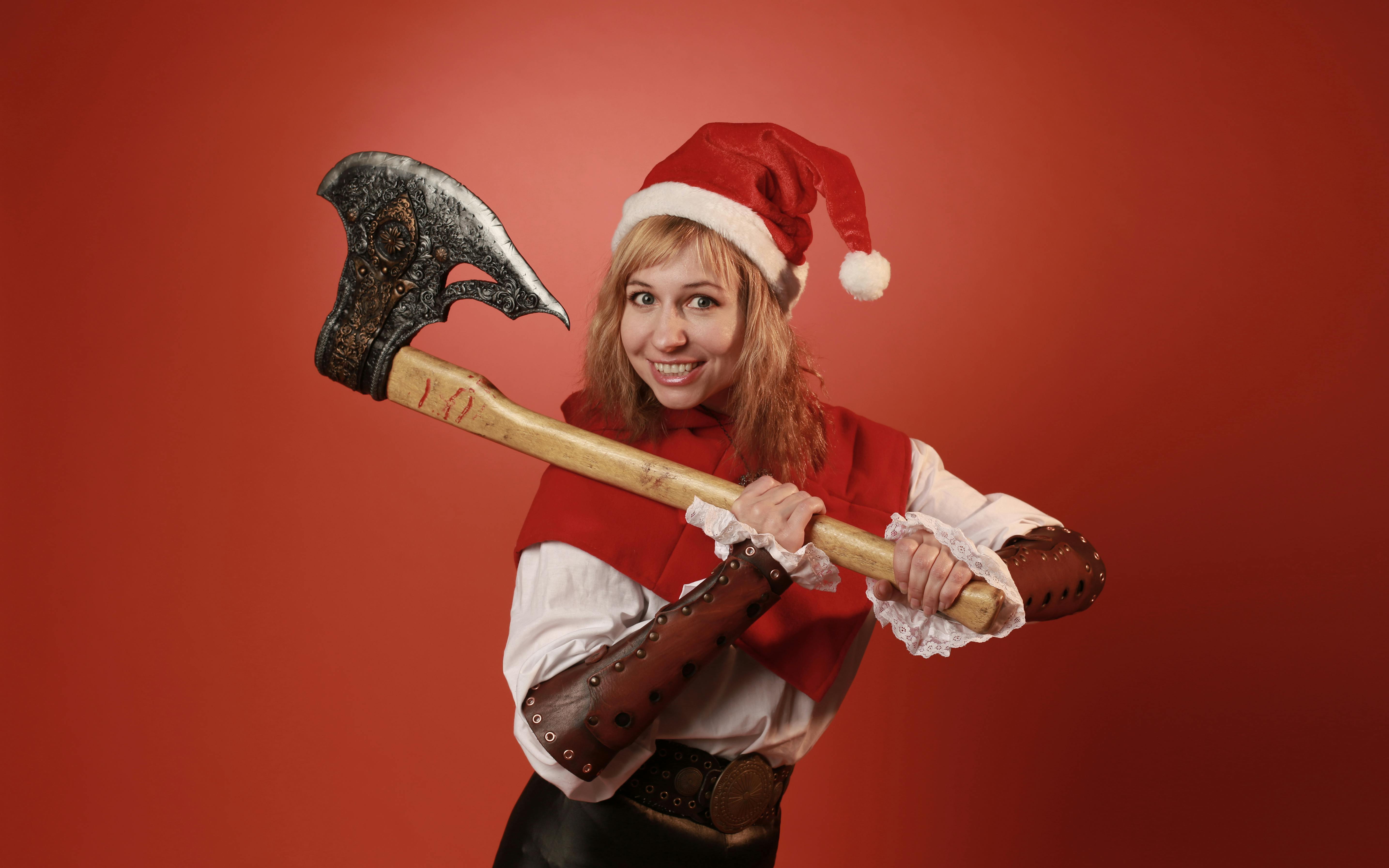 A Woman Holding an Axe while Wearing a Santa Hat · Free Stock Photo