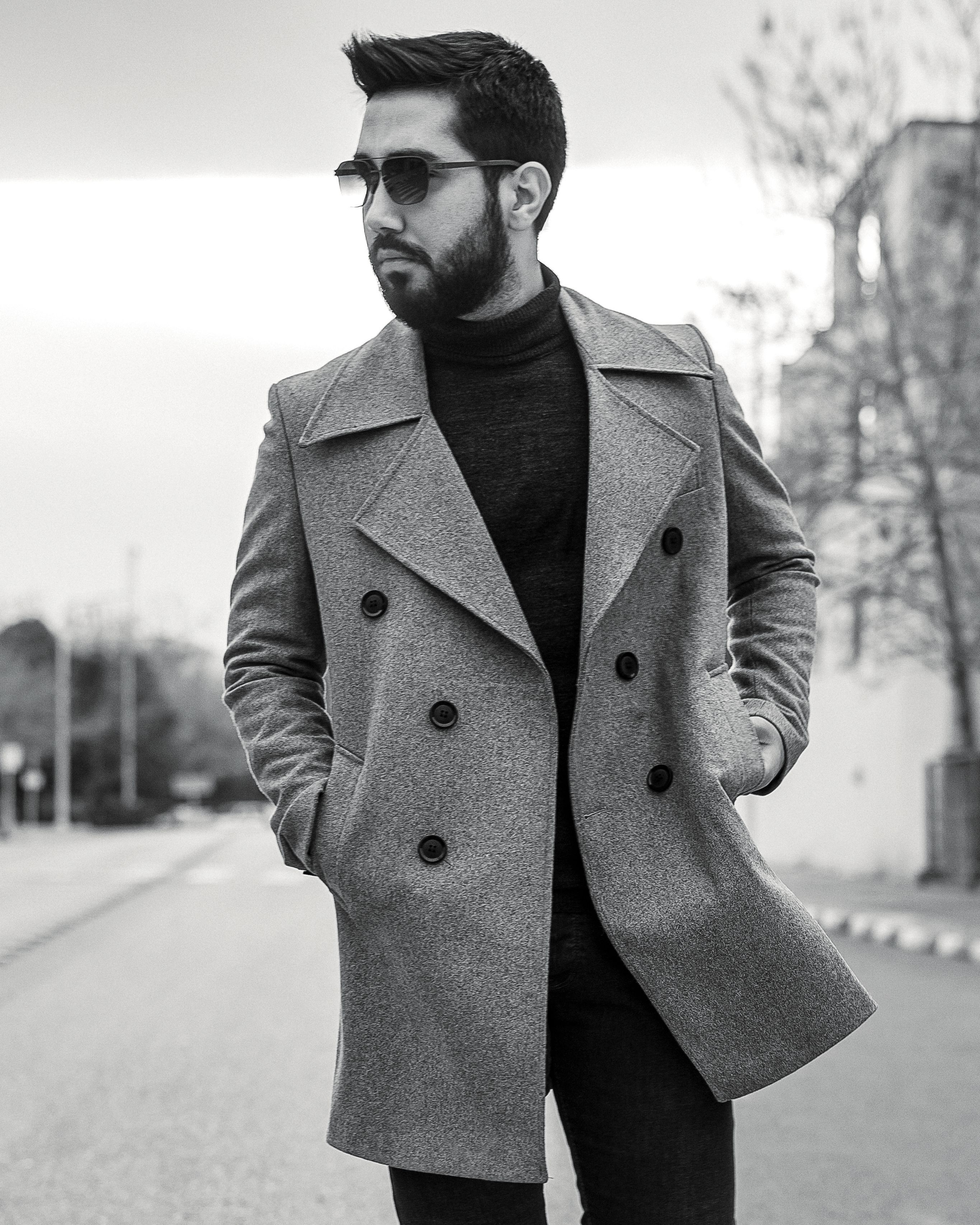 Grayscale Photo of a Man in a Coat Standing on the Road · Free Stock Photo
