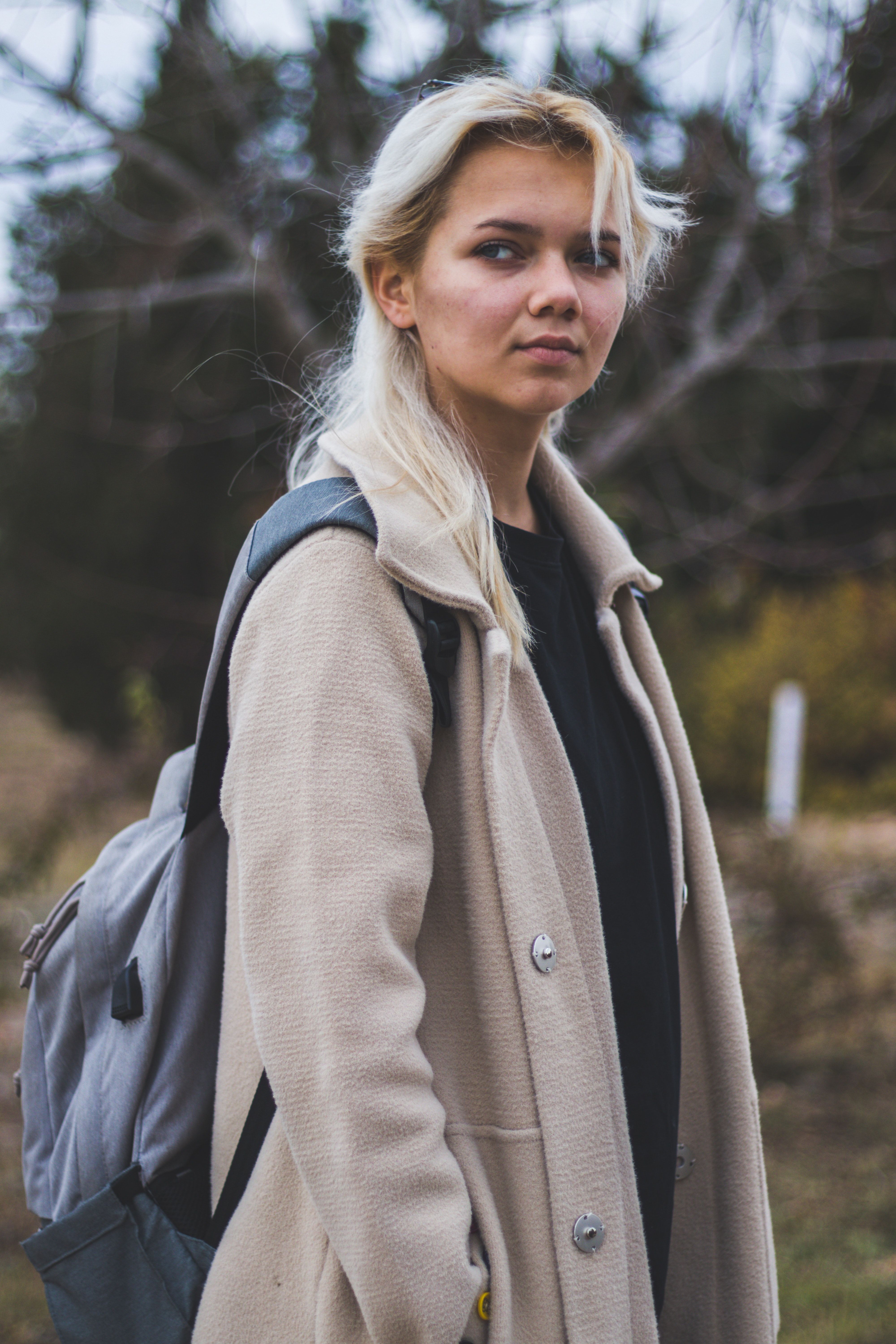 A Woman Draping a Black Coat Over her Shoulders · Free Stock Photo