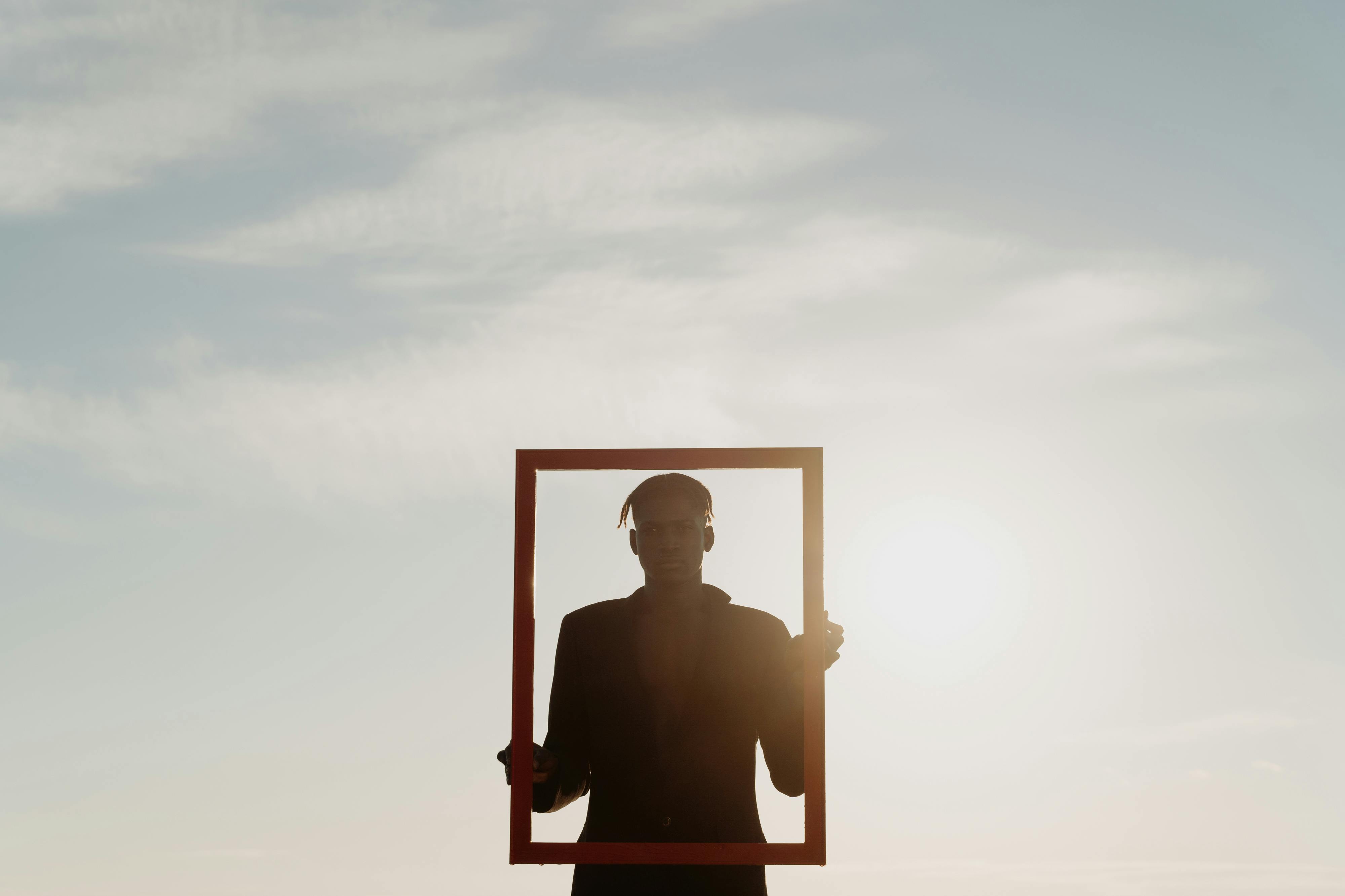Man Holding a Picture Frame under the Sky · Free Stock Photo